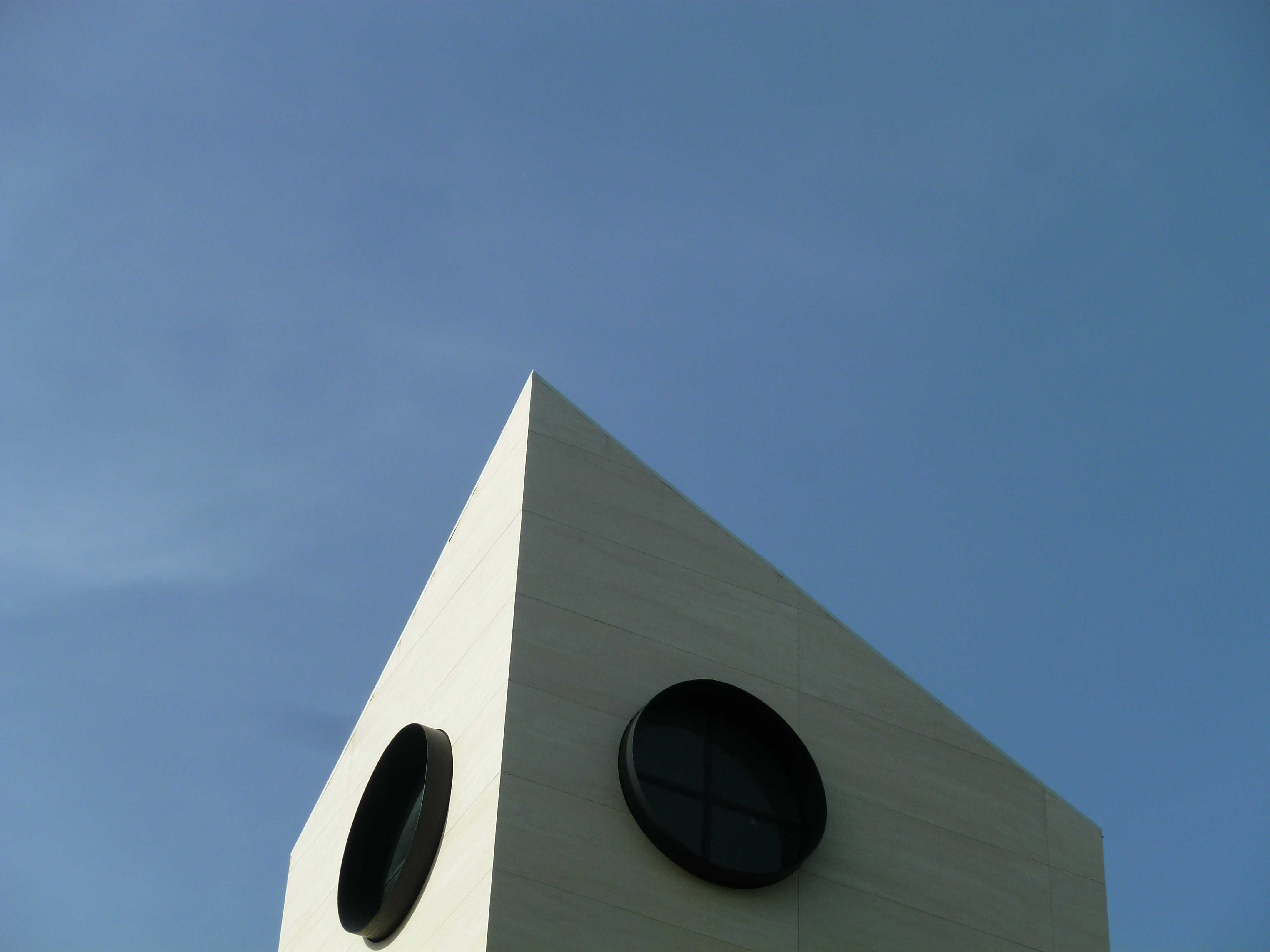 A modern white building against a clear sky.