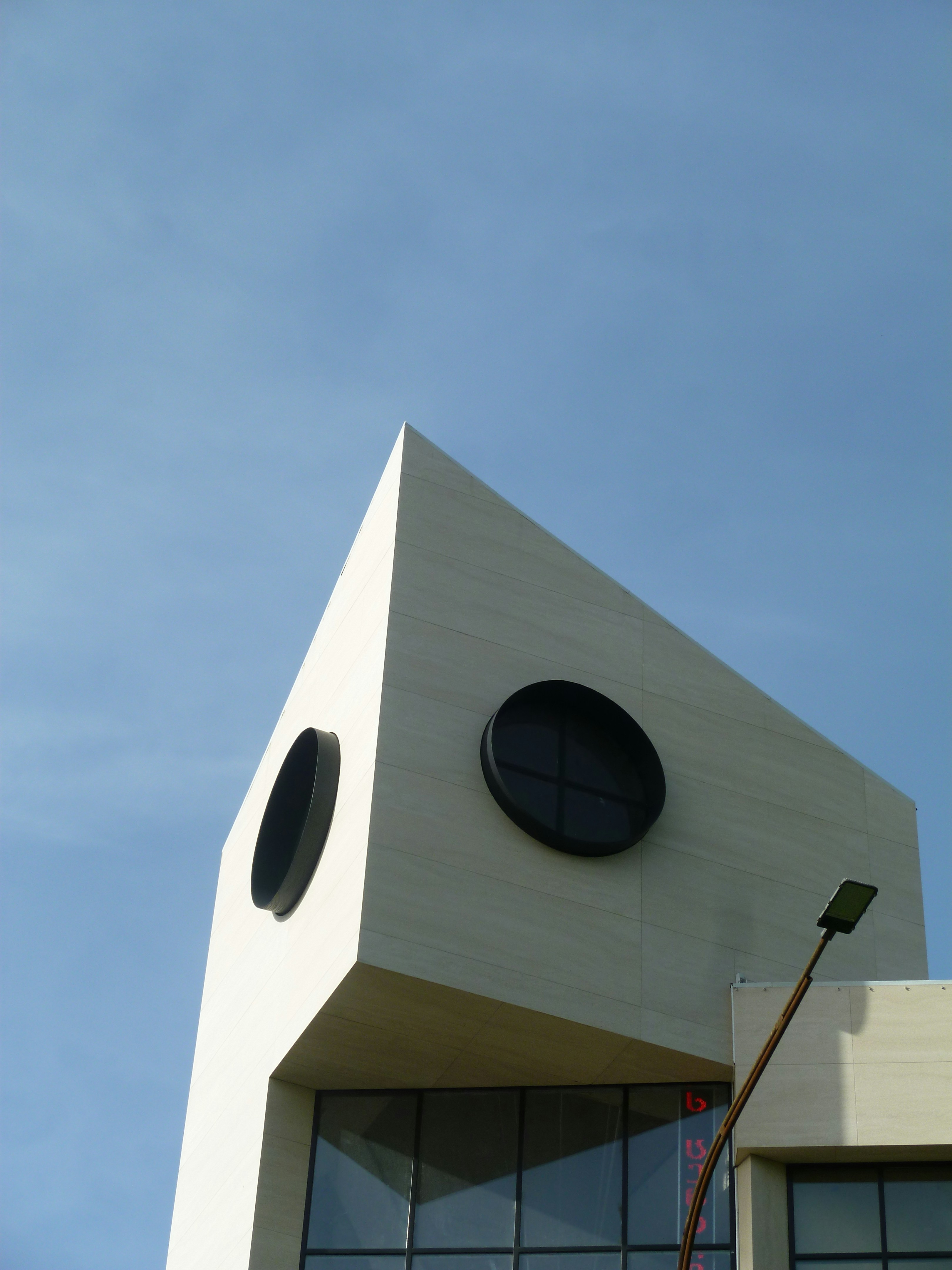 Modern building with circular windows against a blue sky.