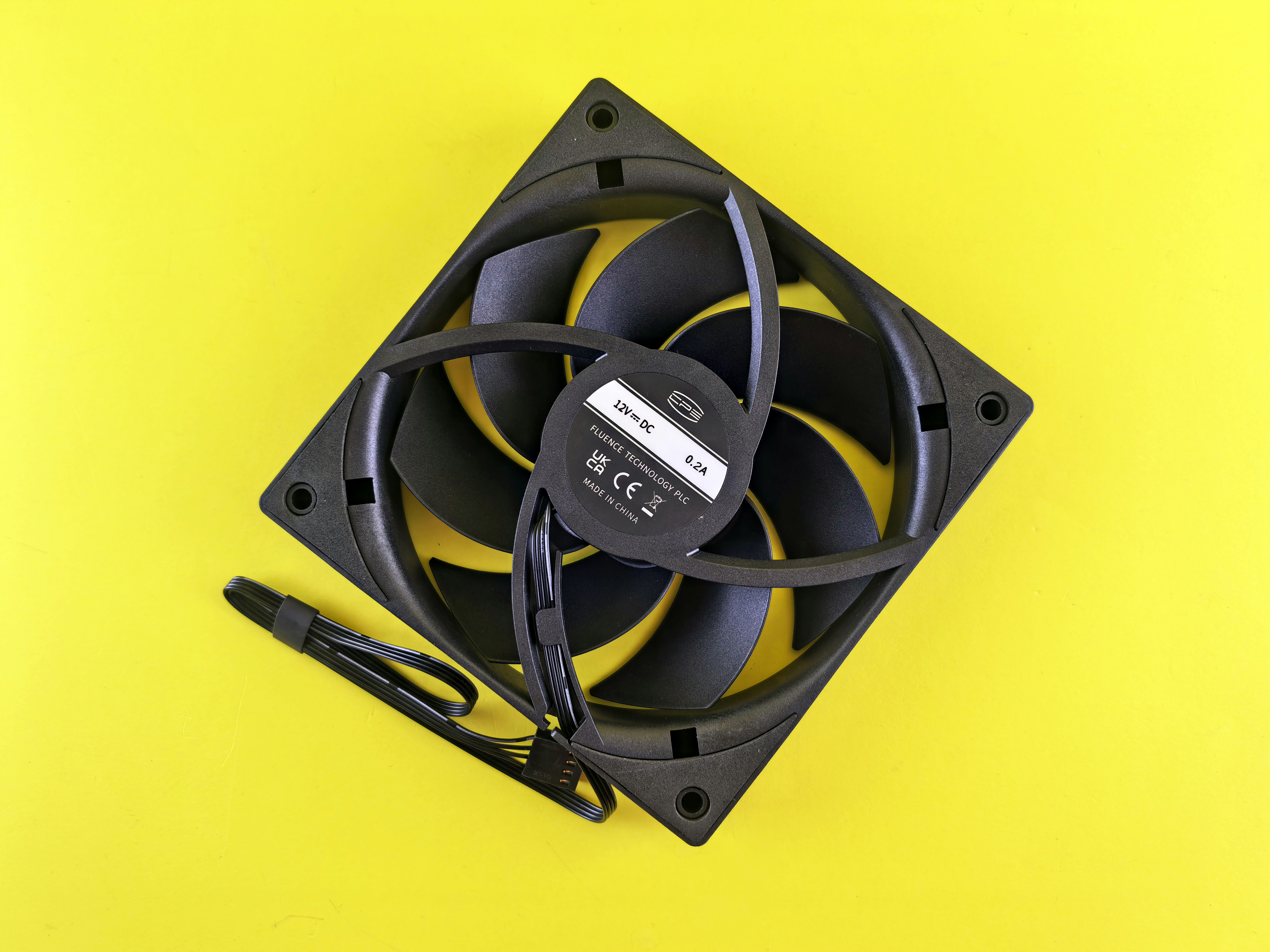 A black PC fan on a yellow background.