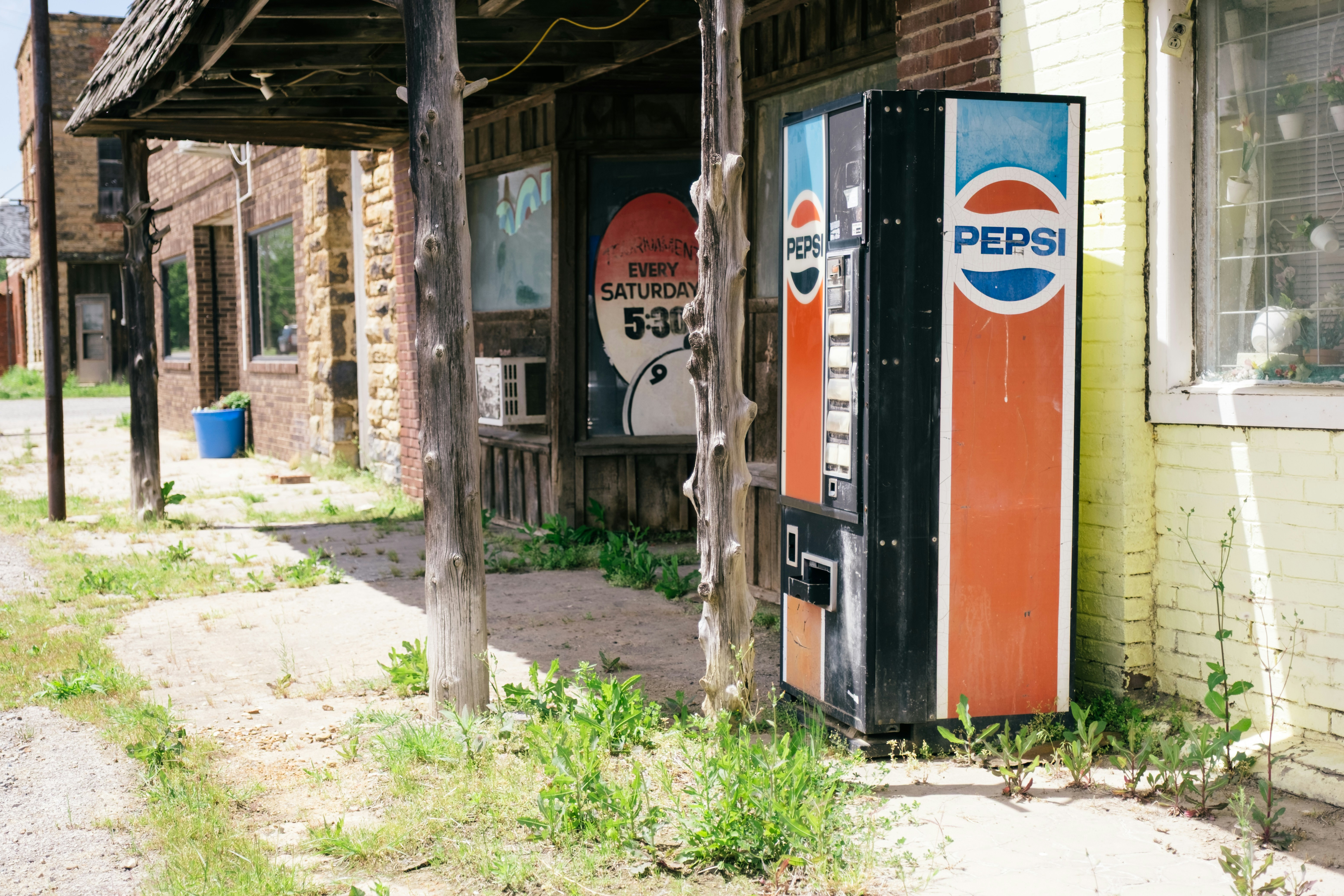 An old pepsi vending machine sits outside.