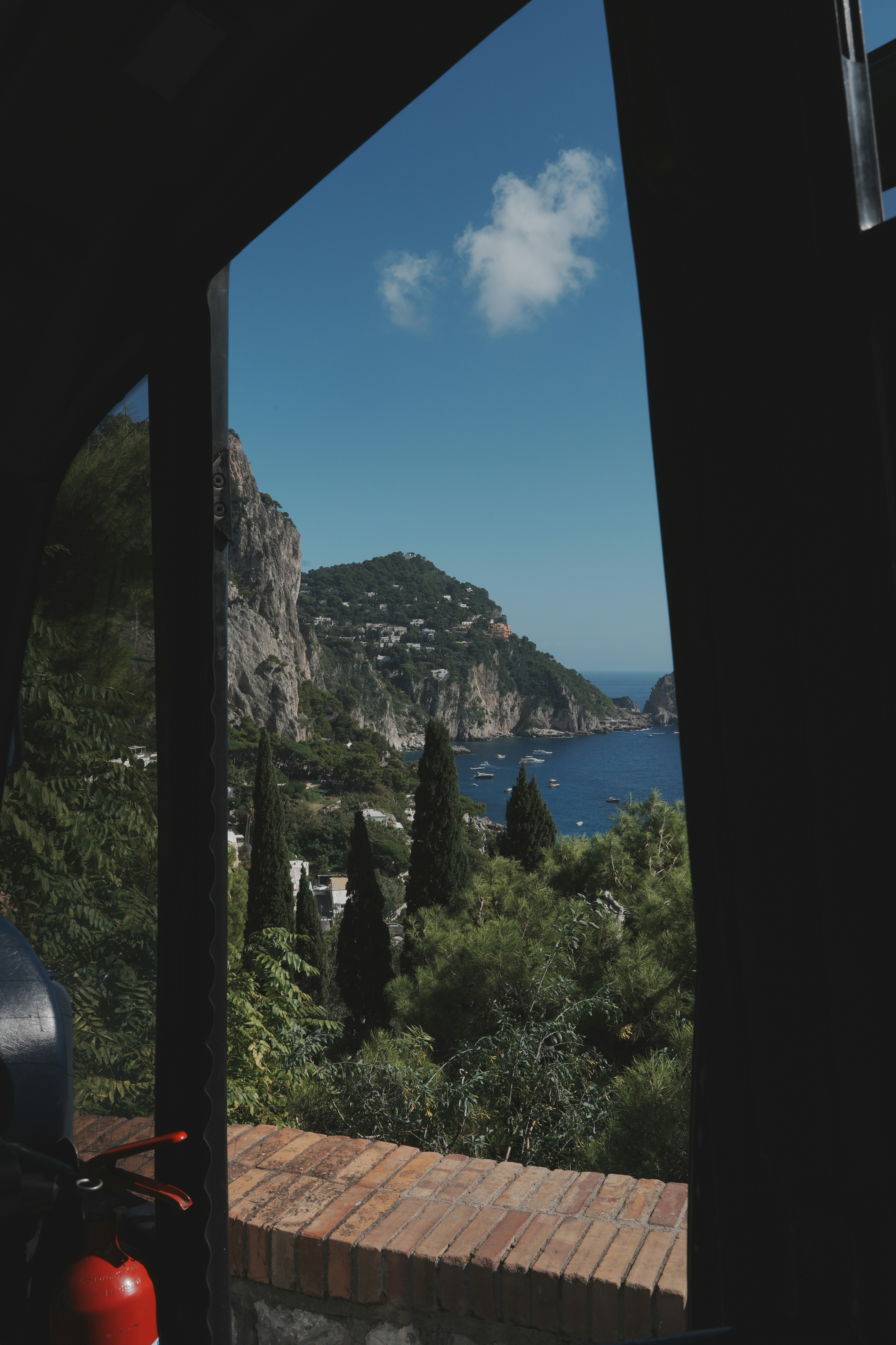 View through a window of mountains and sea.