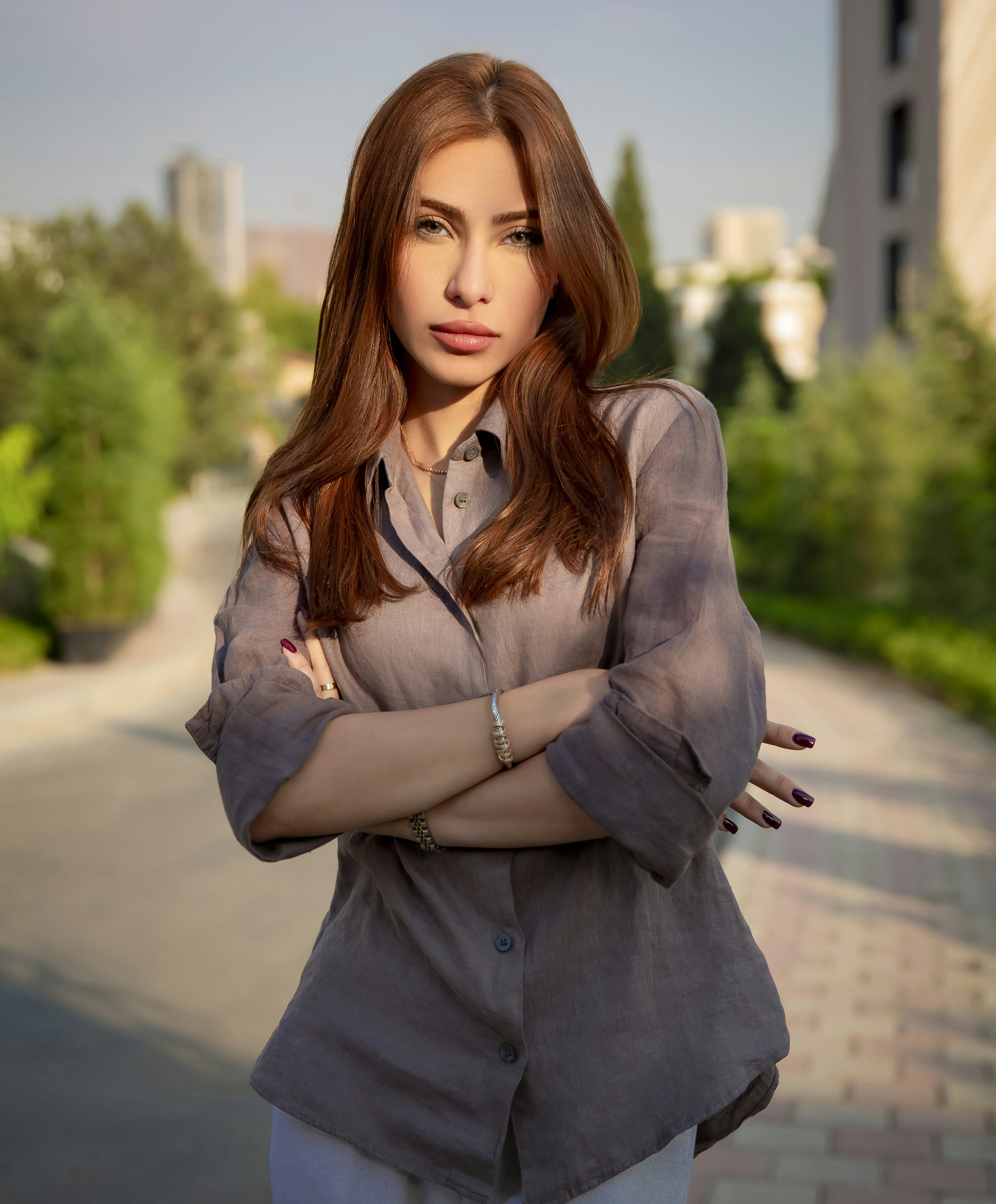 Street photography with most beautiful girl in the world | A woman stands with crossed arms outdoors.