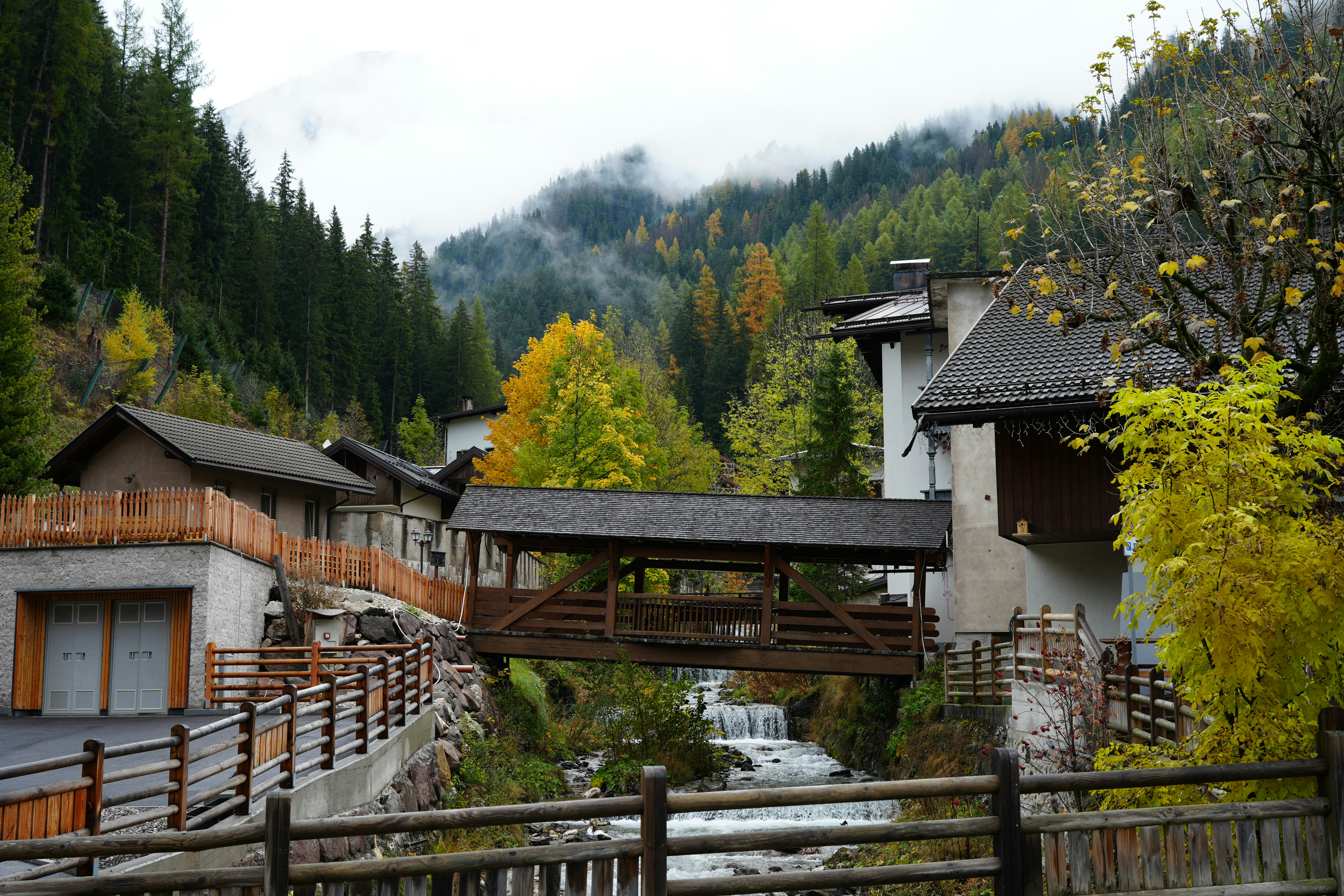 A scenic village sits among autumn-colored mountains.
