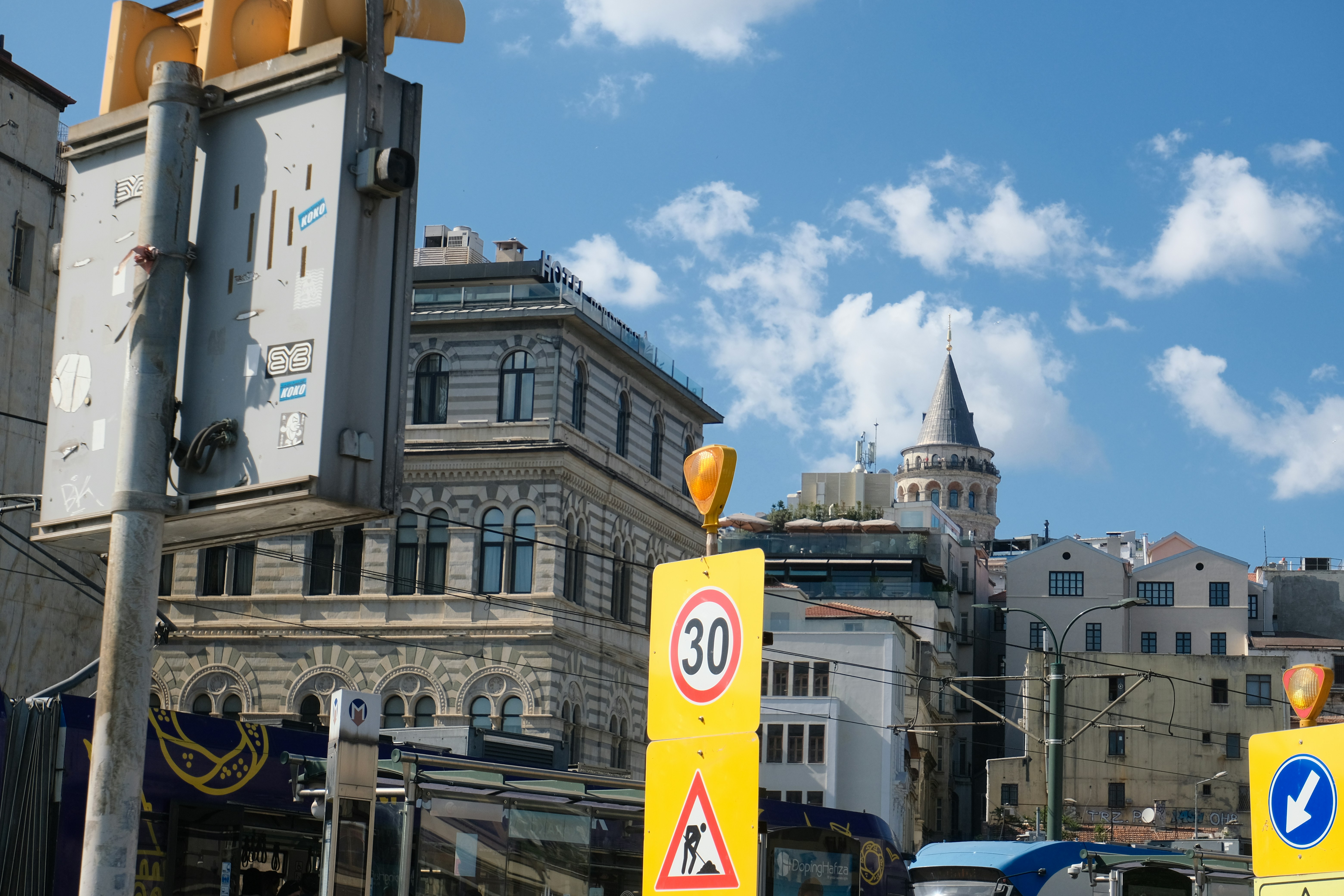 Traffic signs stand in front of city buildings.