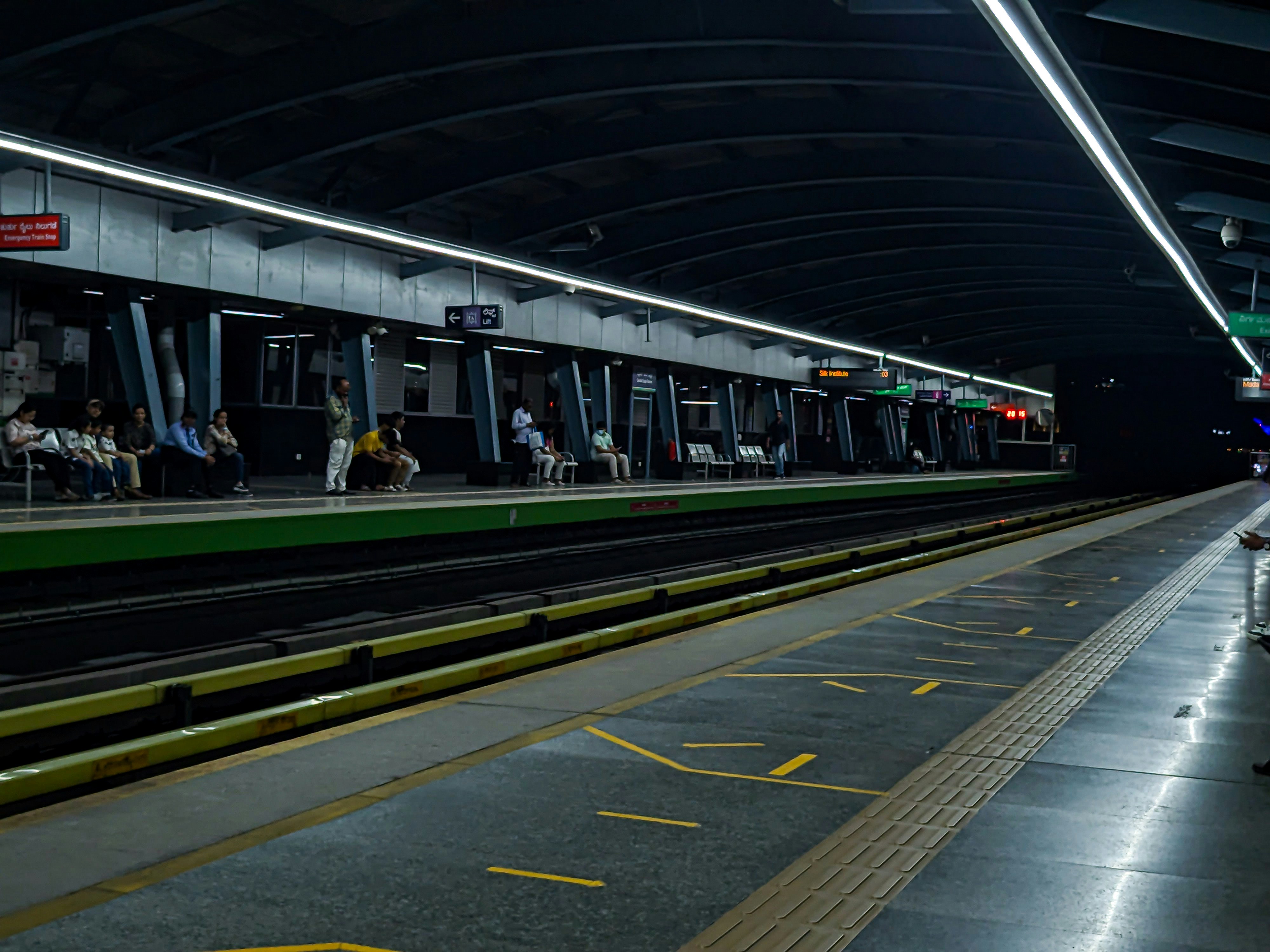 Metro Station 🚥 | People wait at a brightly lit subway station platform.