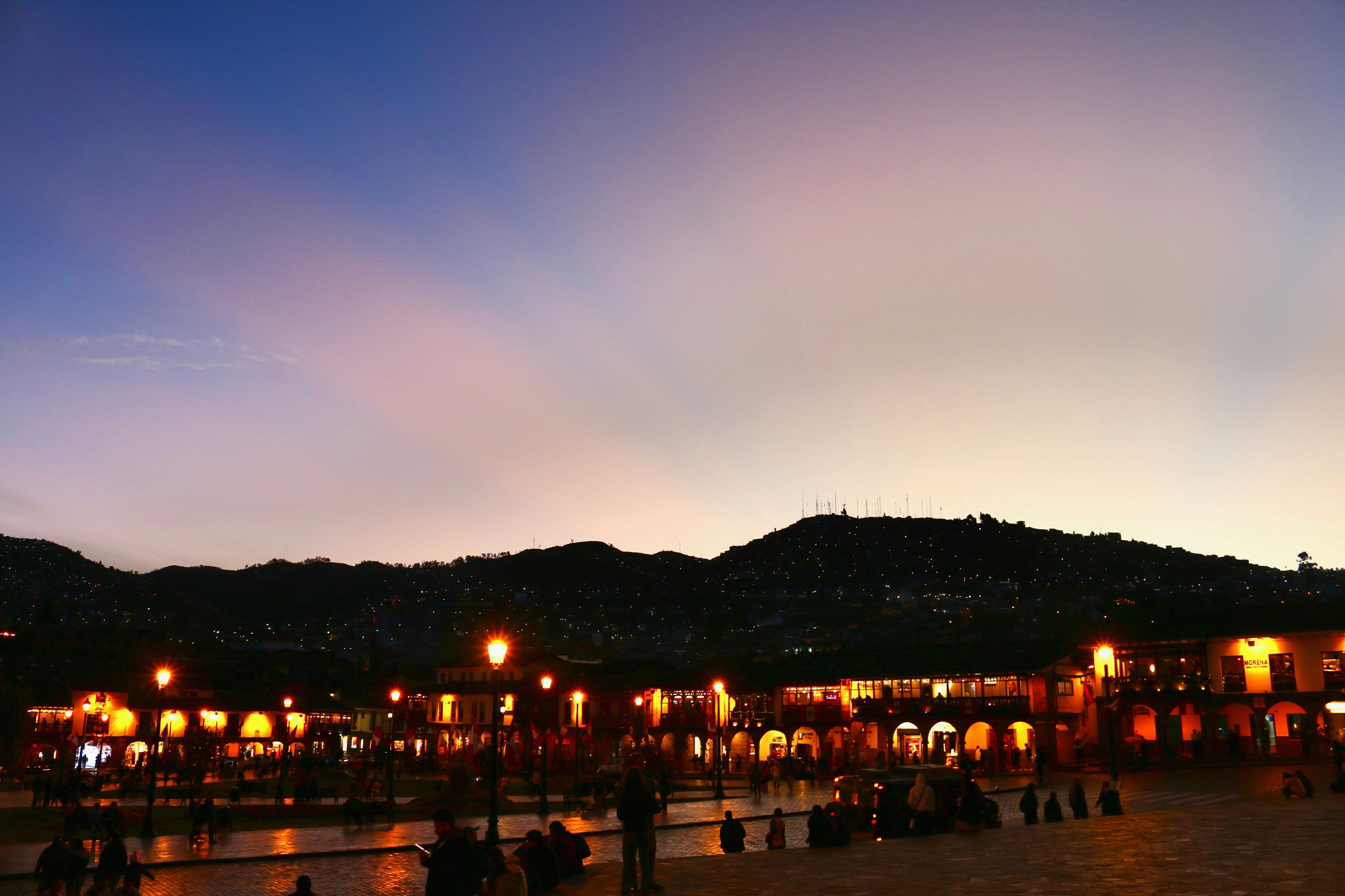City lights glow under a colorful evening sky.