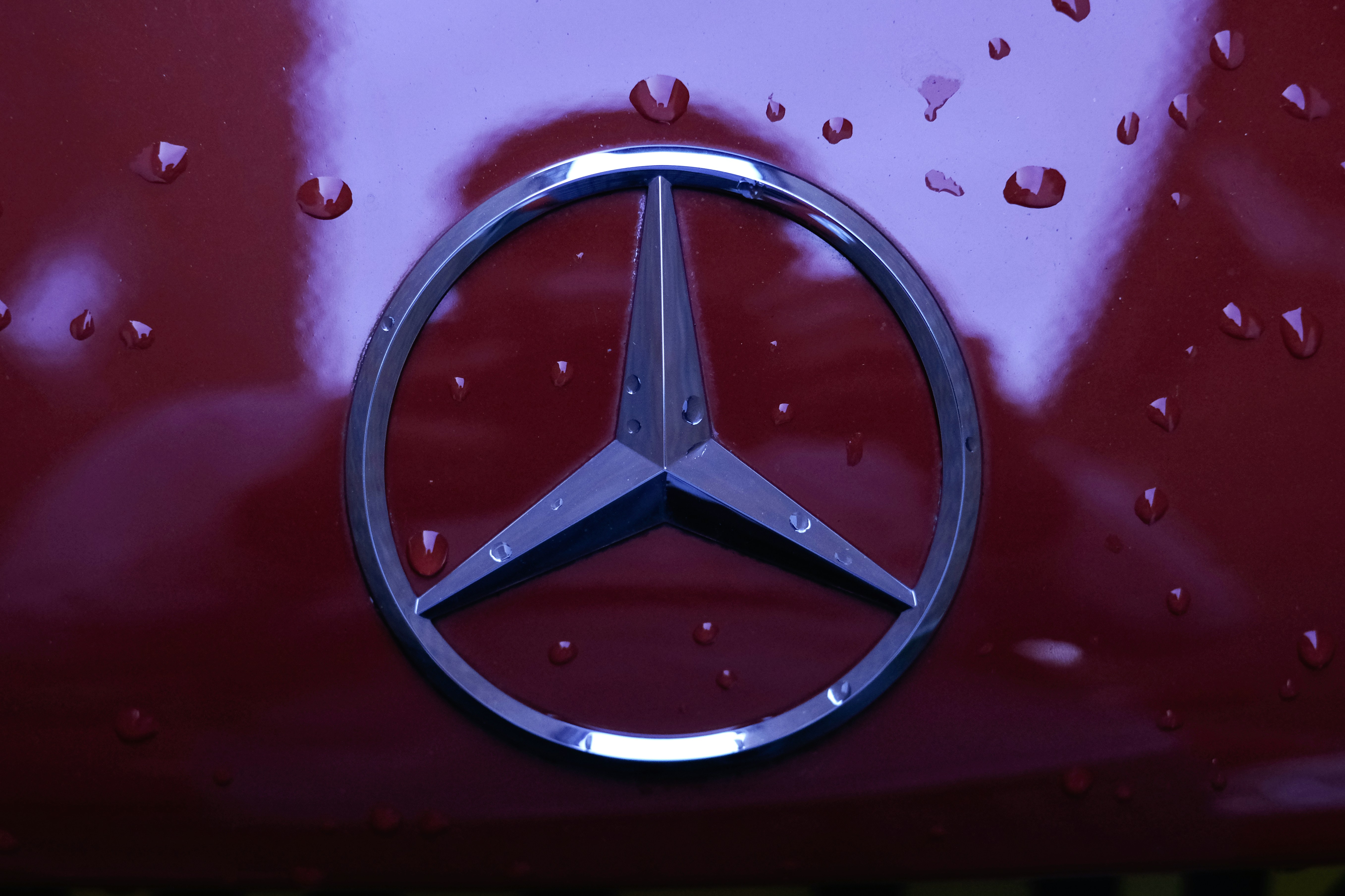 Mercedes-benz logo with water droplets on the surface.