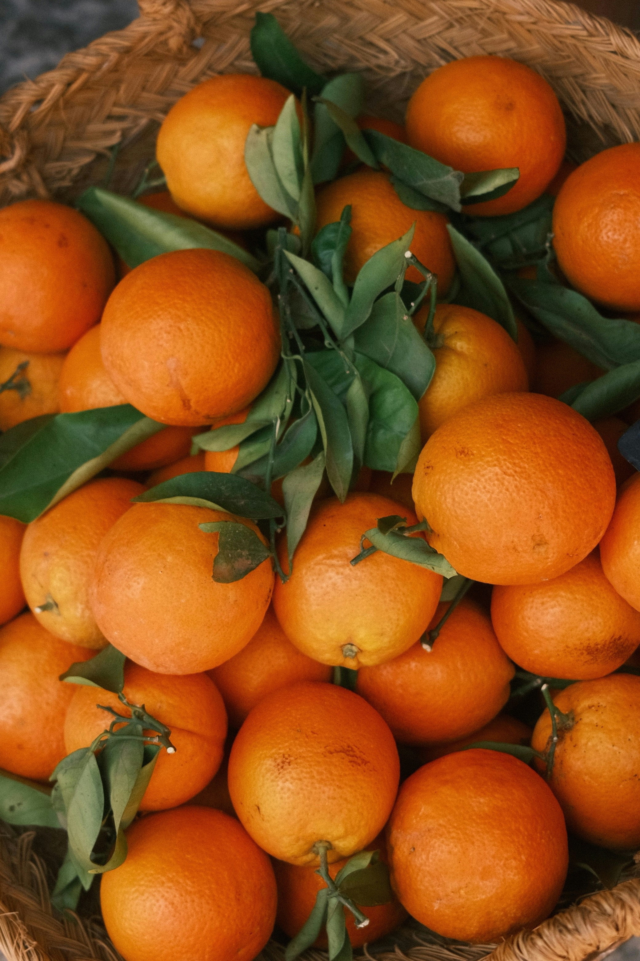 Basket overflowing with fresh, ripe oranges.