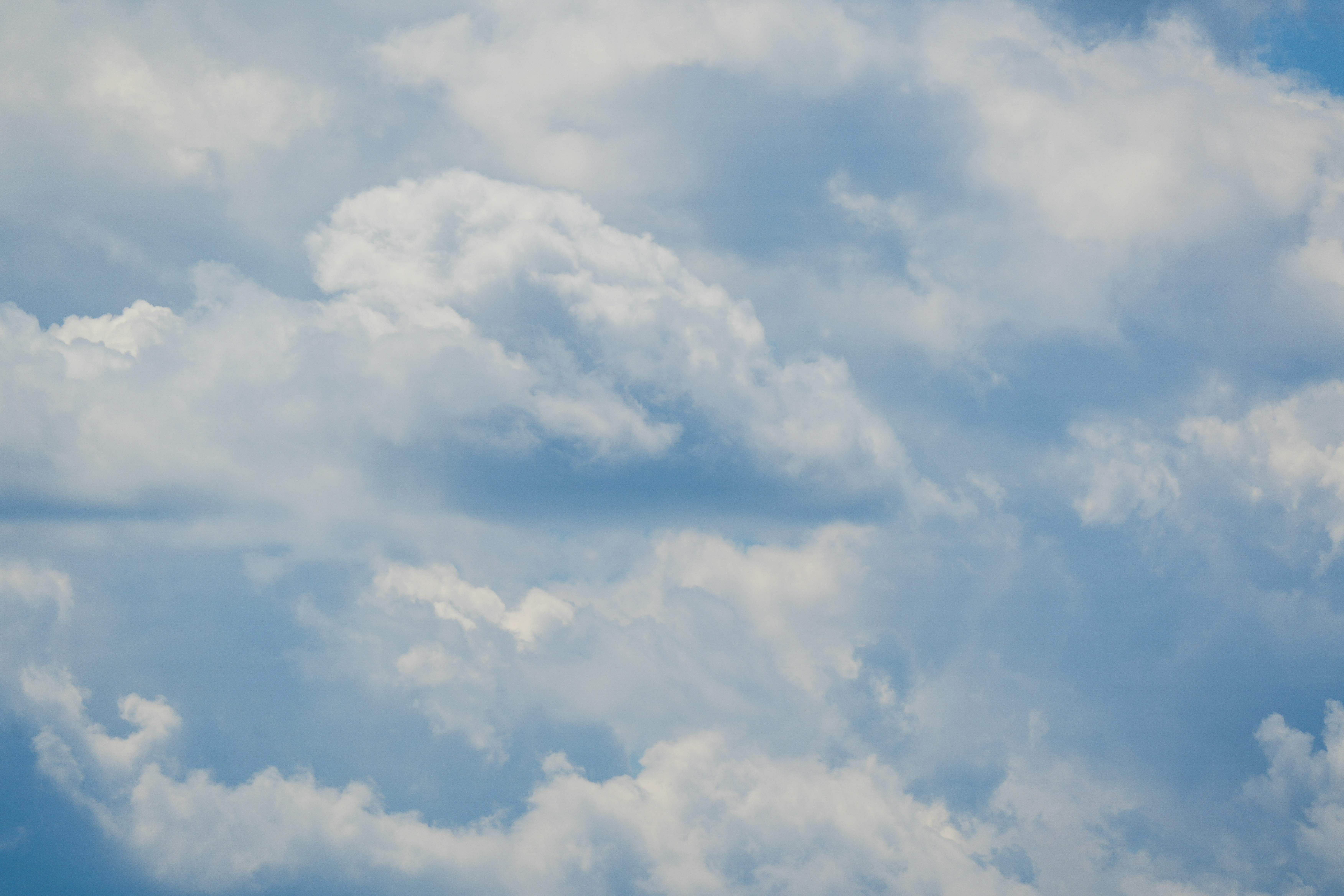 Blue sky filled with fluffy white clouds.