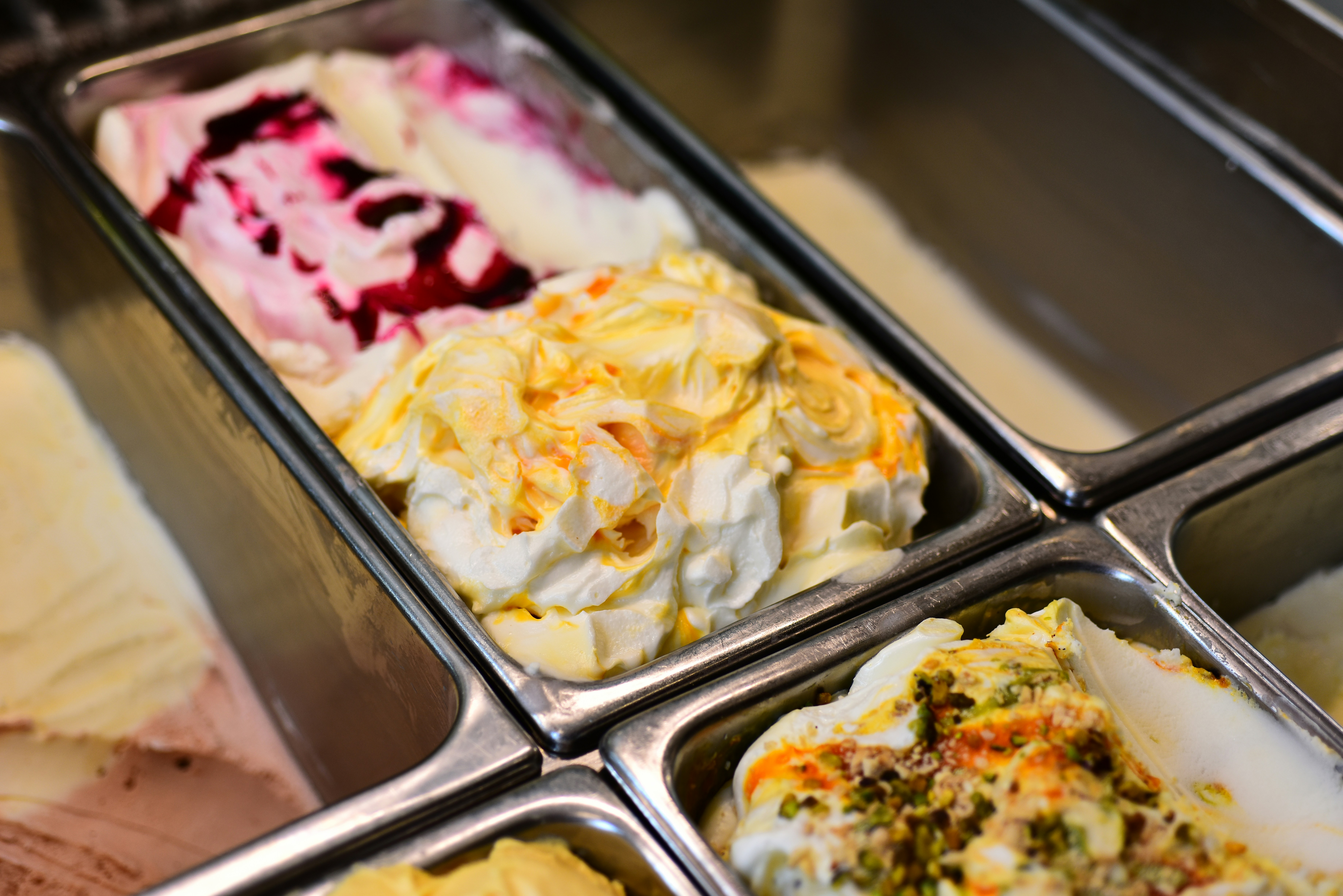 Chill & Choose: A Colorful Ice Cream Counter Showcase. Scoops of Delight: Flavored Ice Cream in Sleek Metal Containers.