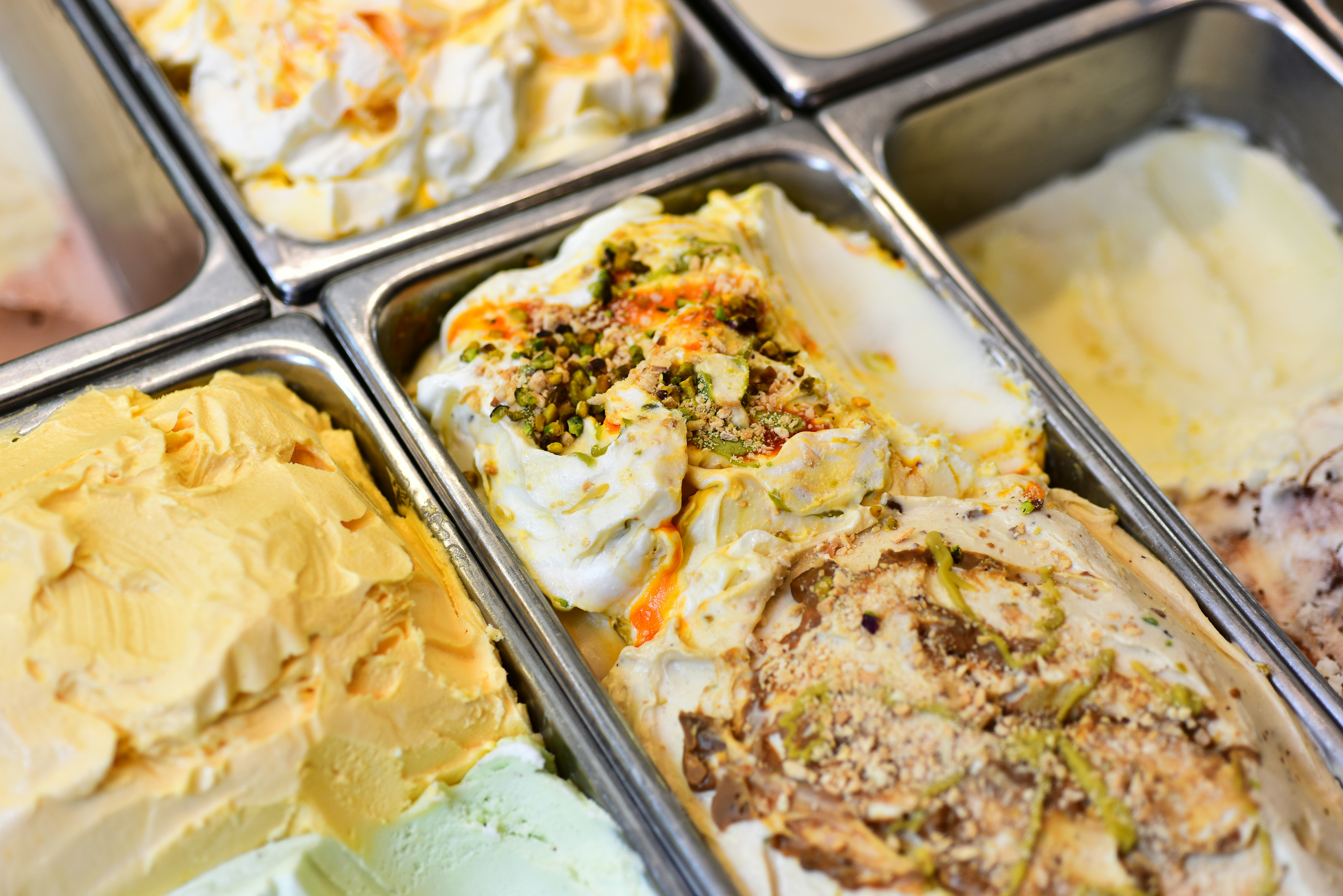Chill & Choose: A Colorful Ice Cream Counter Showcase. Scoops of Delight: Flavored Ice Cream in Sleek Metal Containers.