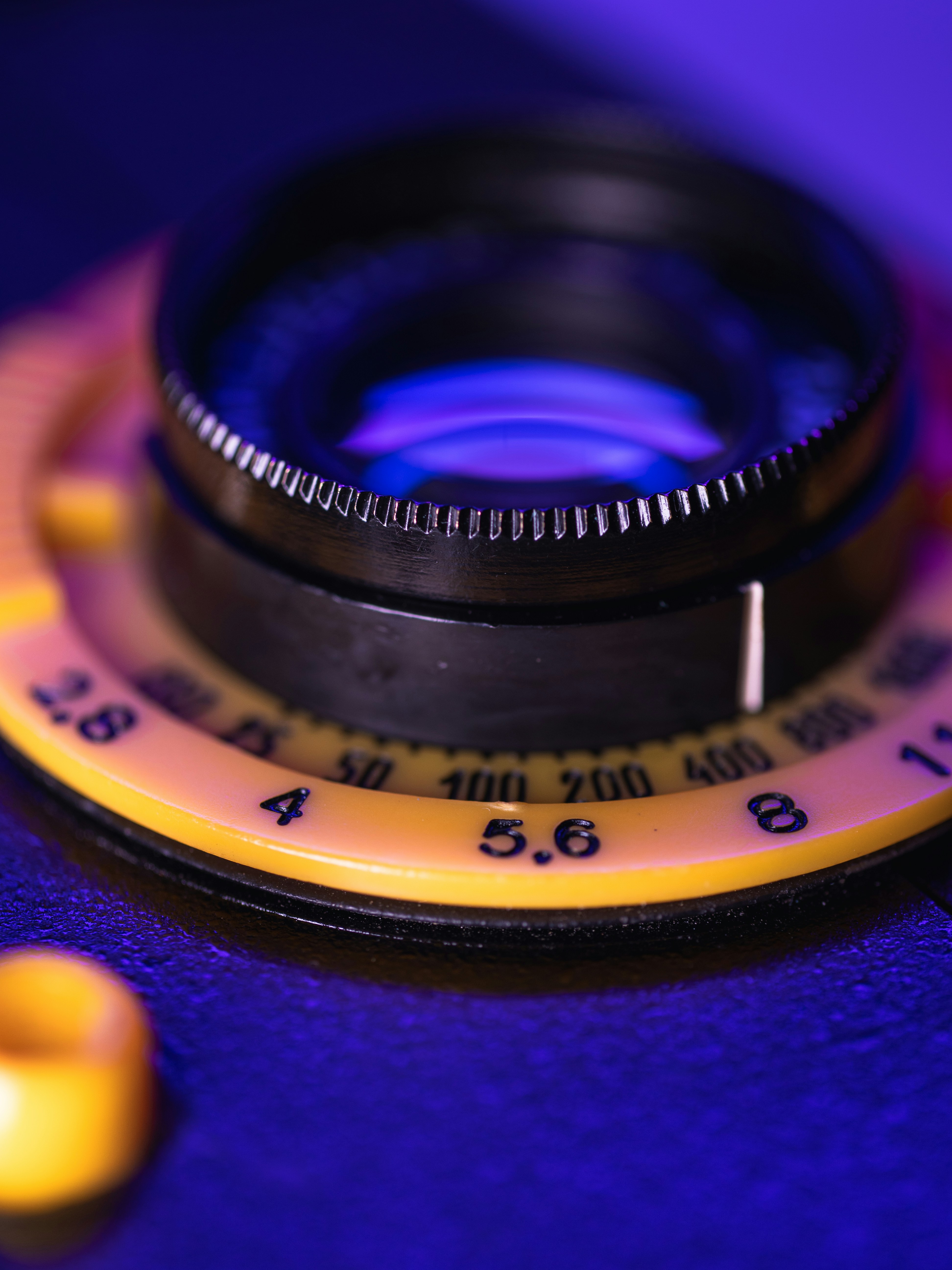 Neon-Blue Aperture: a Macro Close-Up of a Vintage Lens Ring