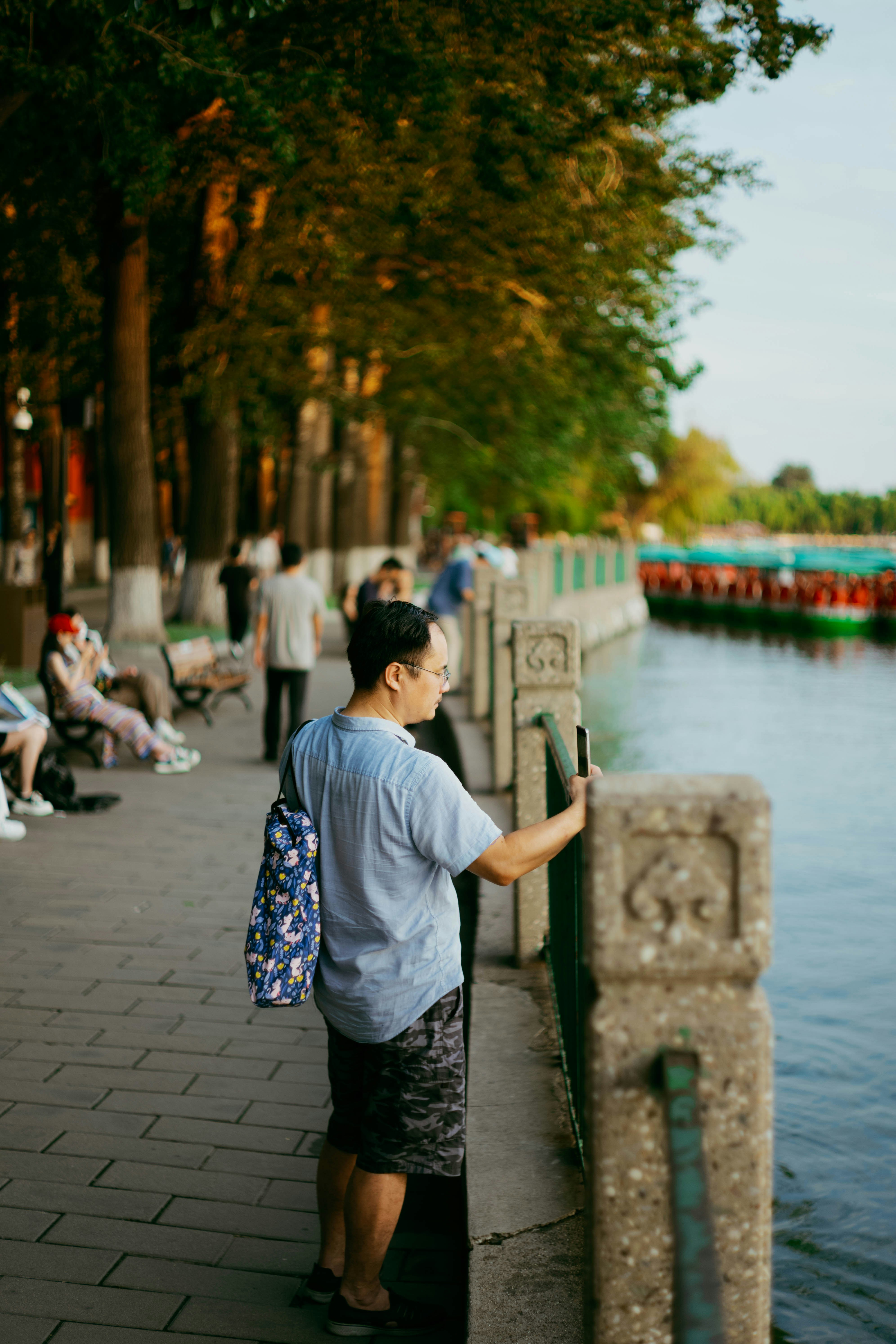 Man taking a photo by the water.