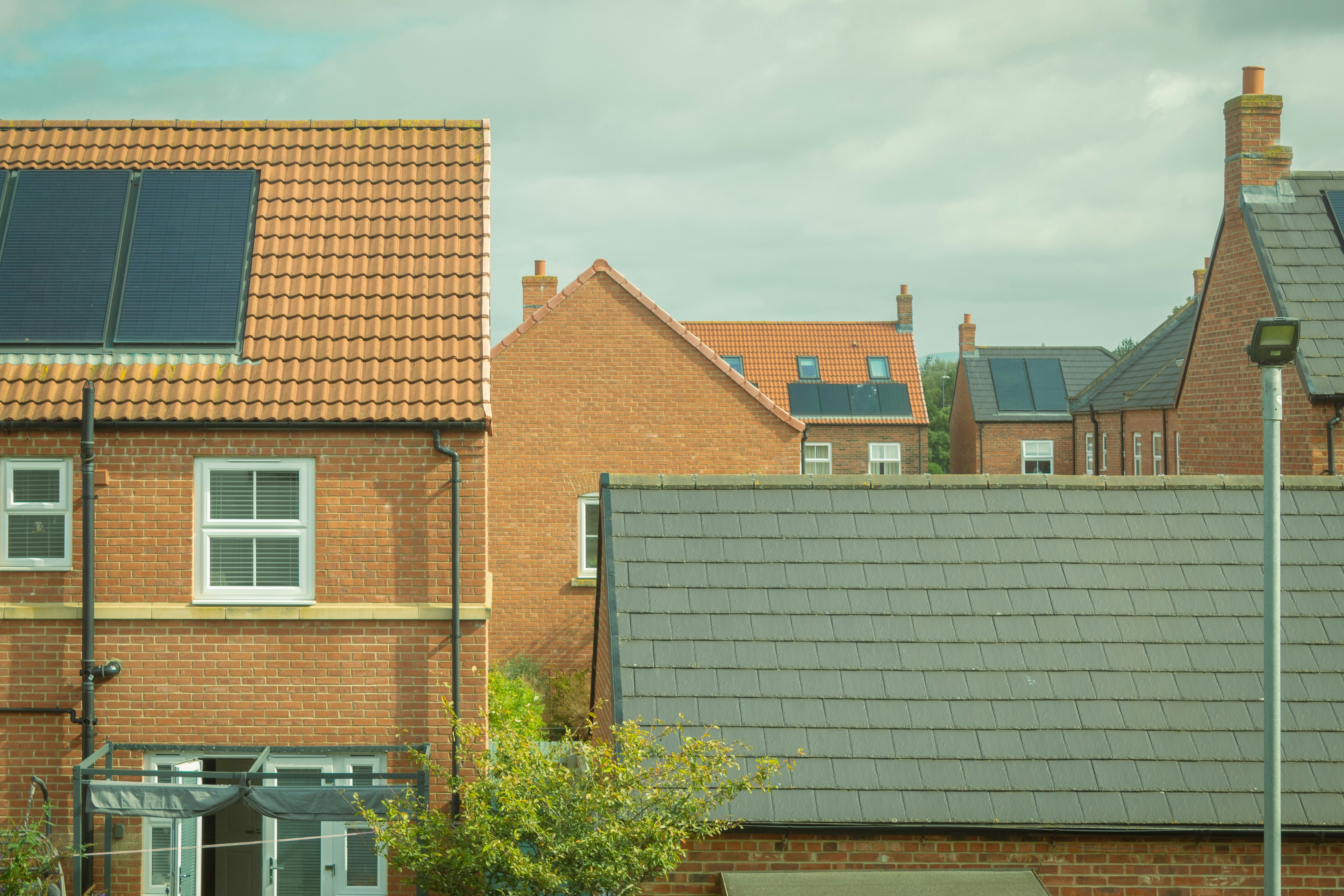 UK houses | Houses with solar panels are shown in the image.