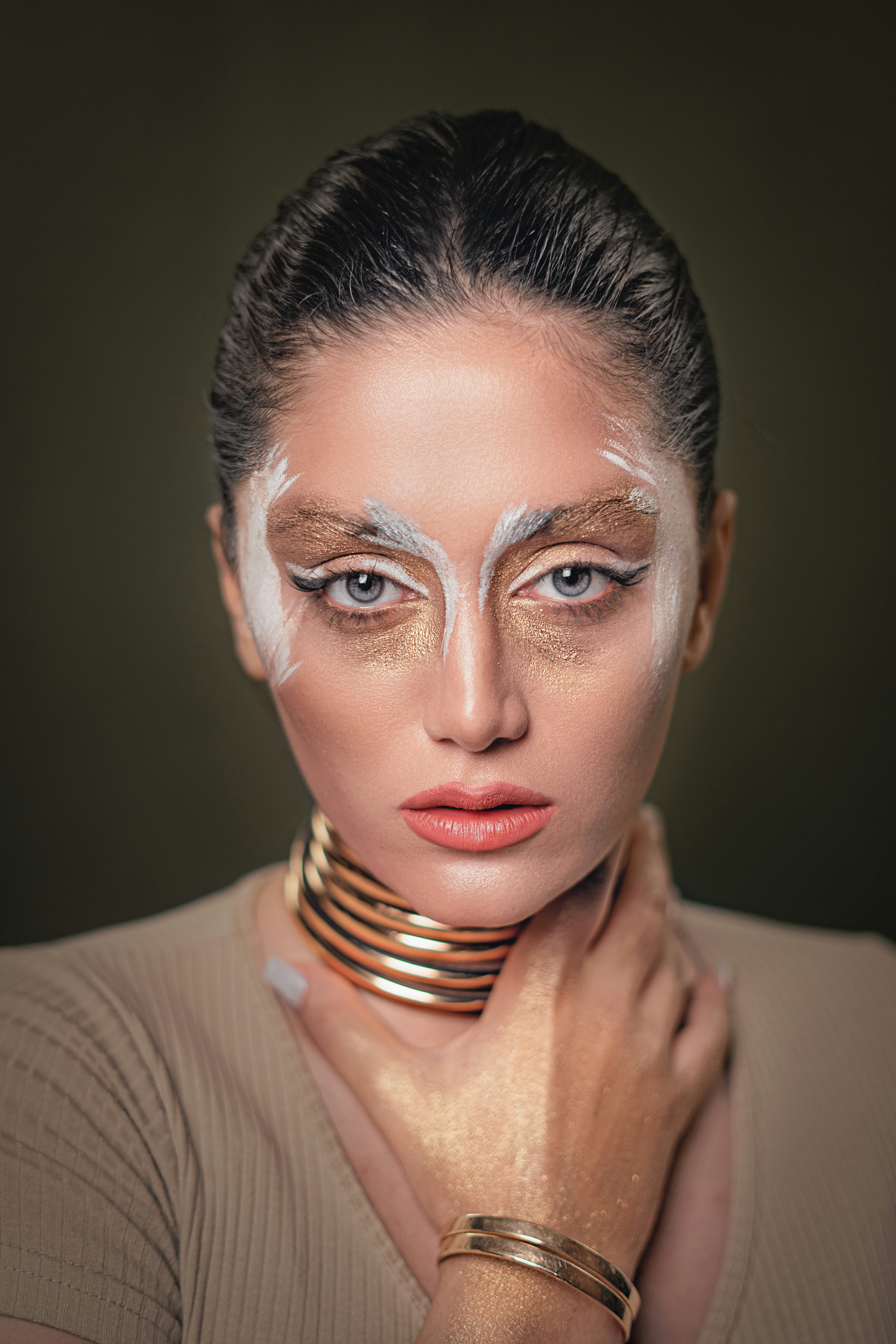 Woman with artistic makeup and golden accessories