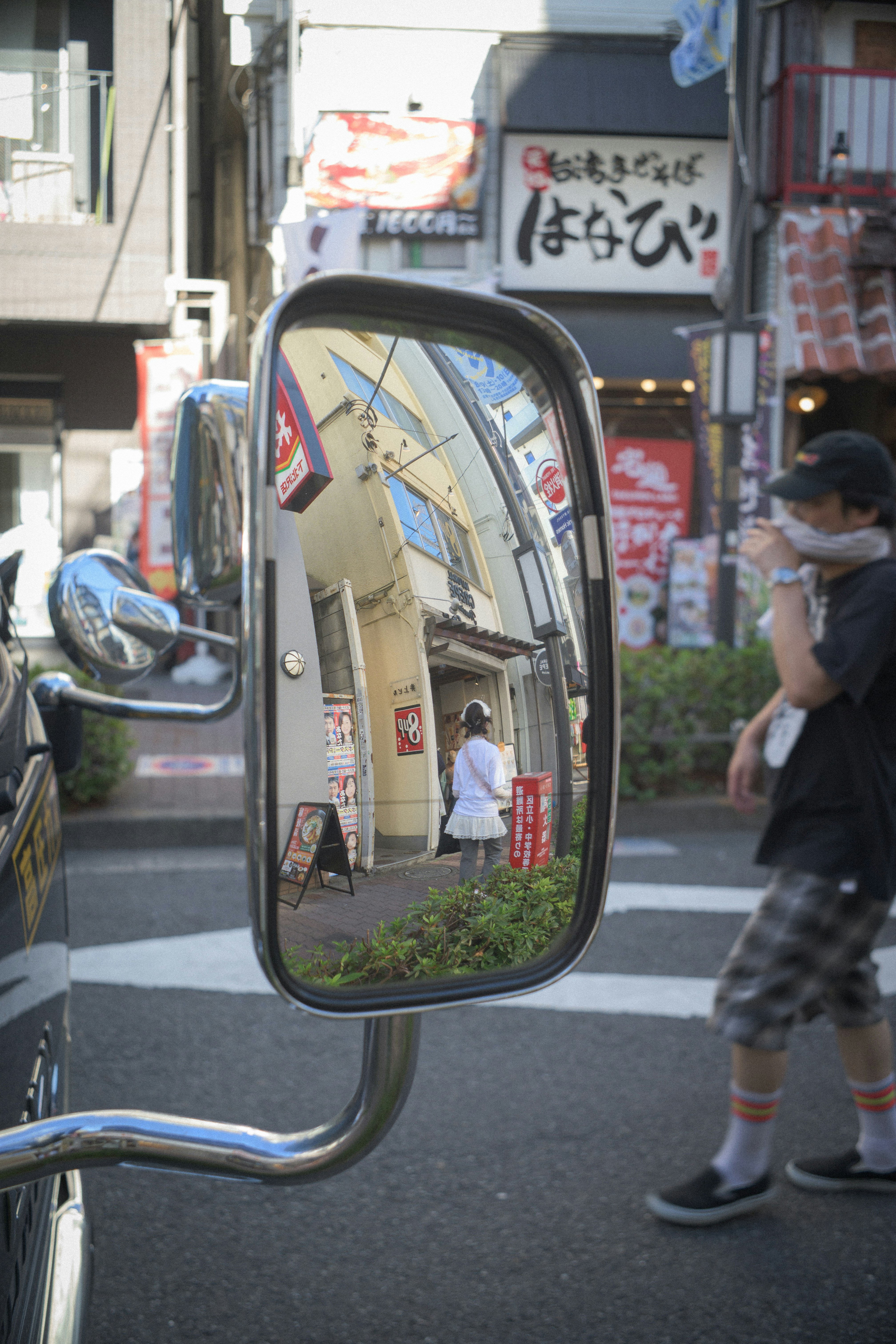 A street scene reflected in a side mirror.