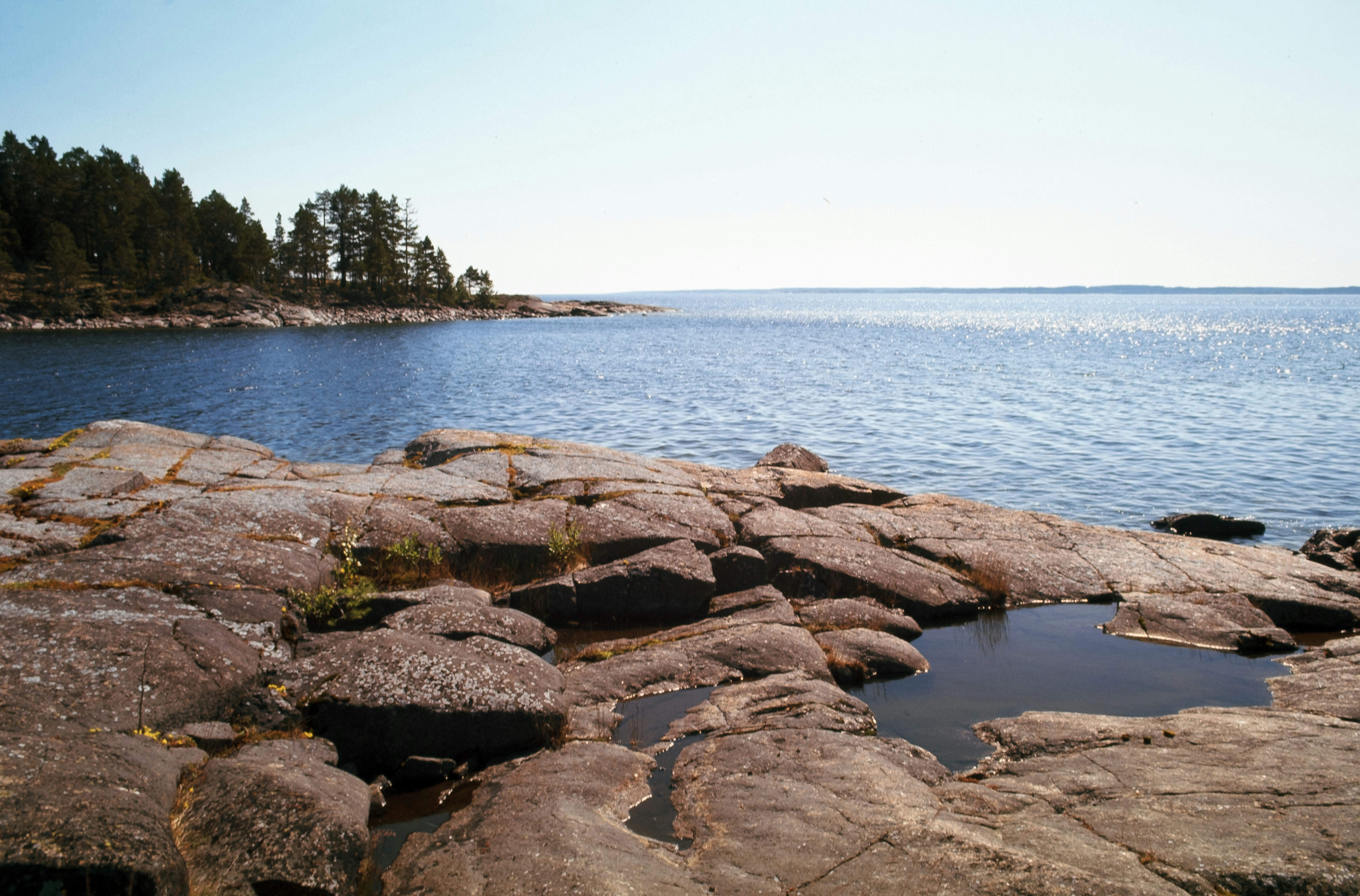 Rocky shoreline meets a calm, blue lake.