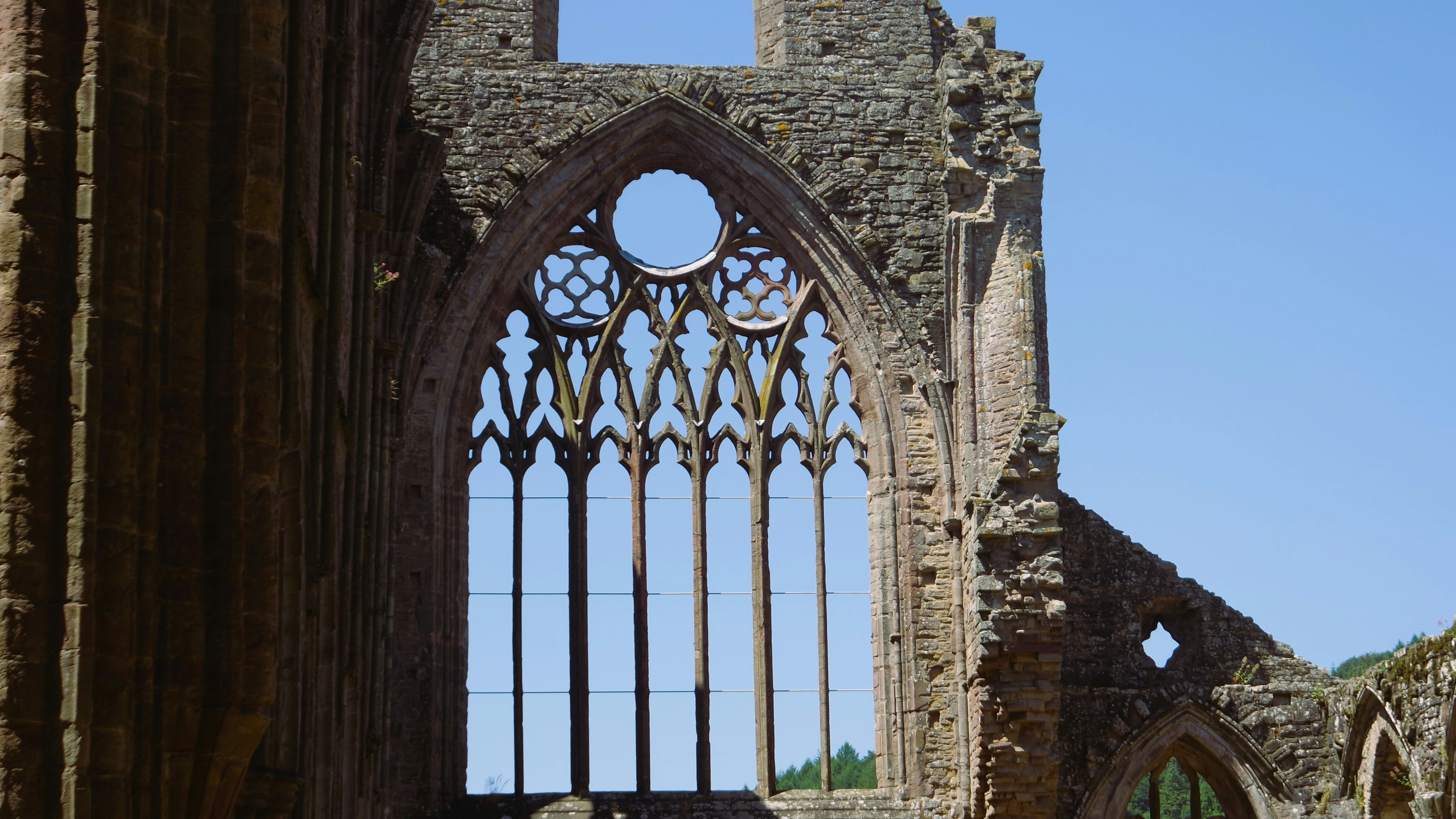 Ruins of an abbey with arched windows.