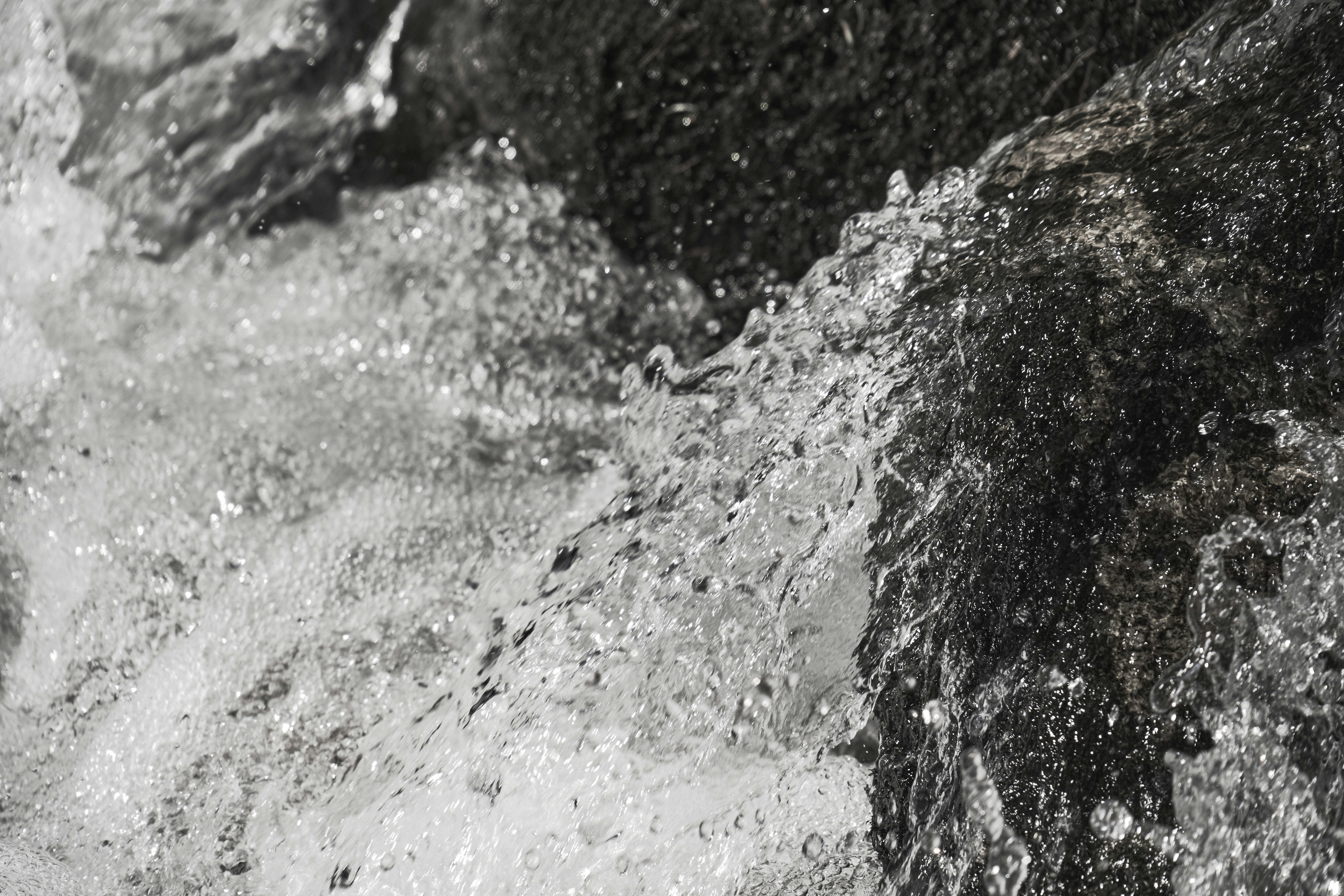 Dynamic splashes of water cascading over dark rocks, capturing the essence of nature's movement and energy.