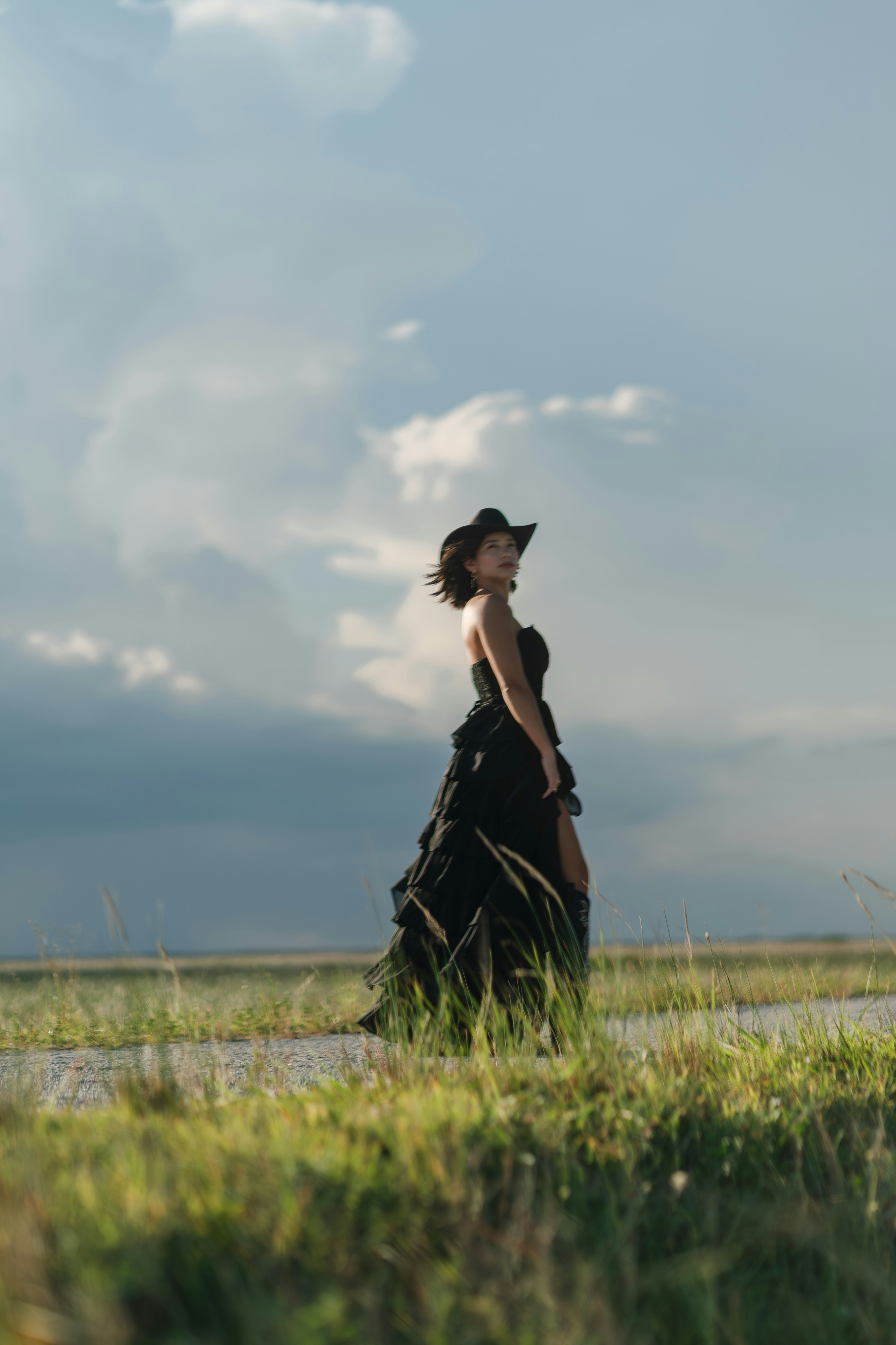 Silhouette in a Black Gown: Quiet Drama Under Expansive Sky