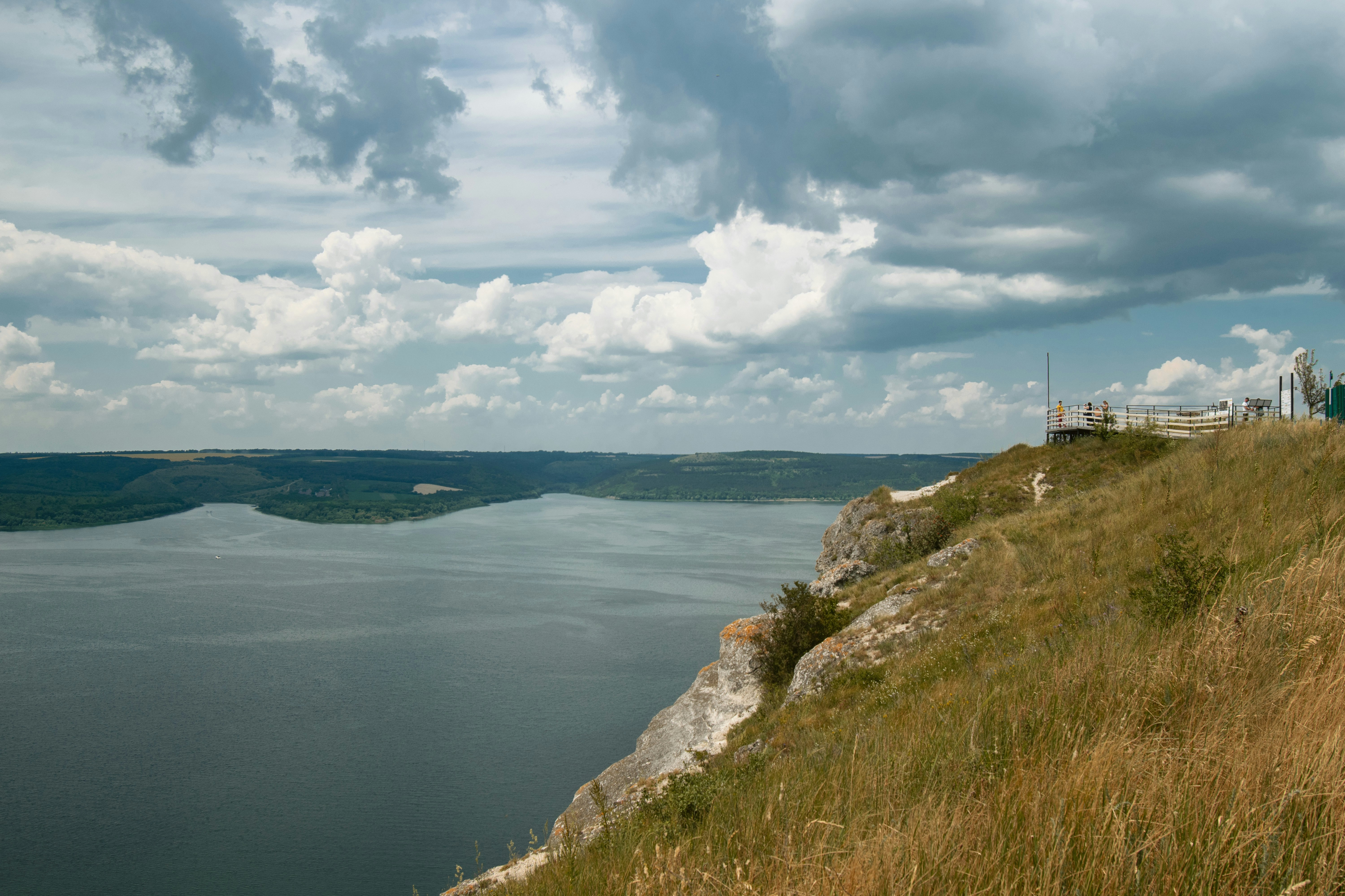 Dramatic clouds hover over a scenic lake view.