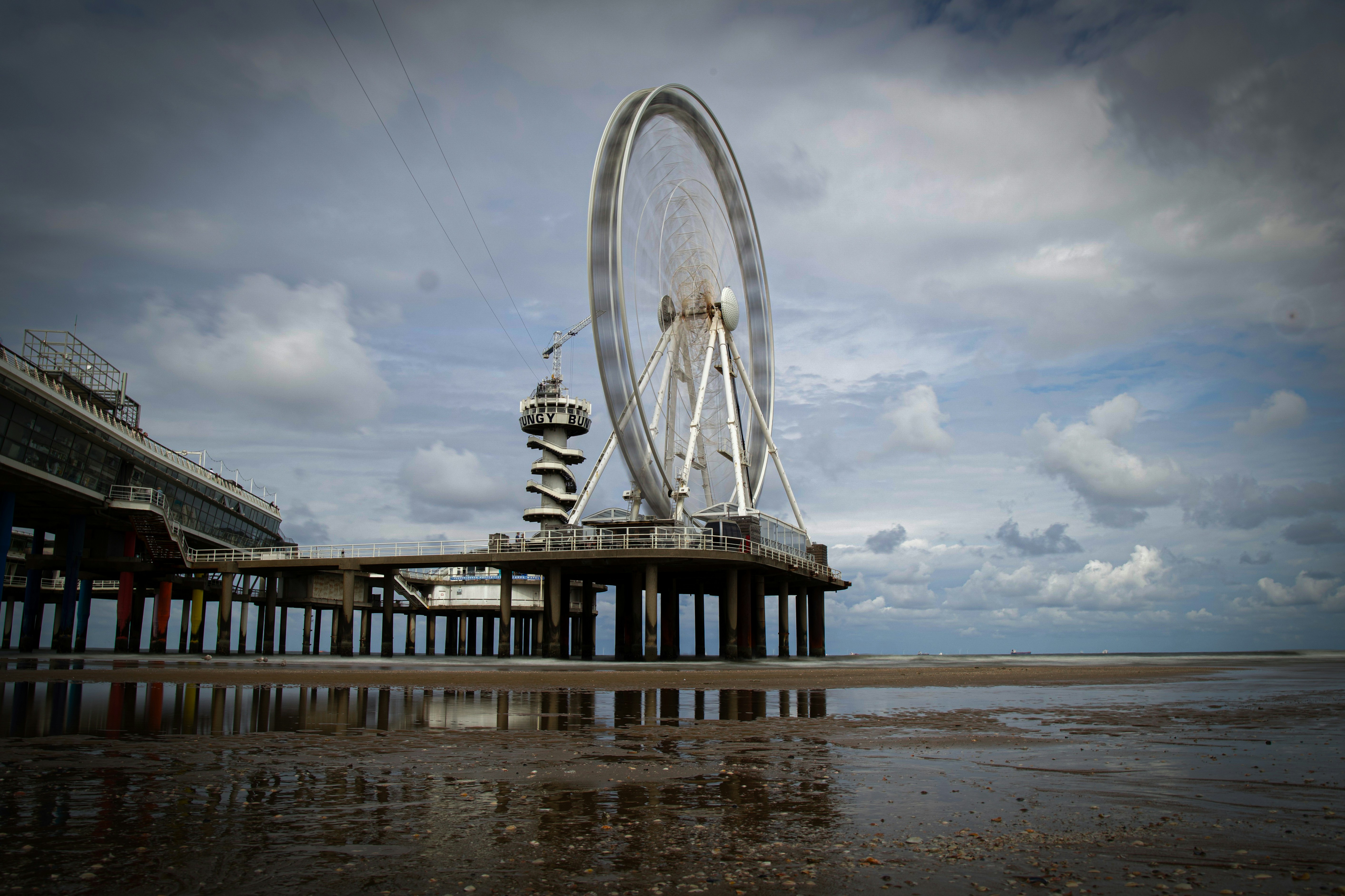 Ferris wheel on the beach | A ferris wheel stands over the beach.