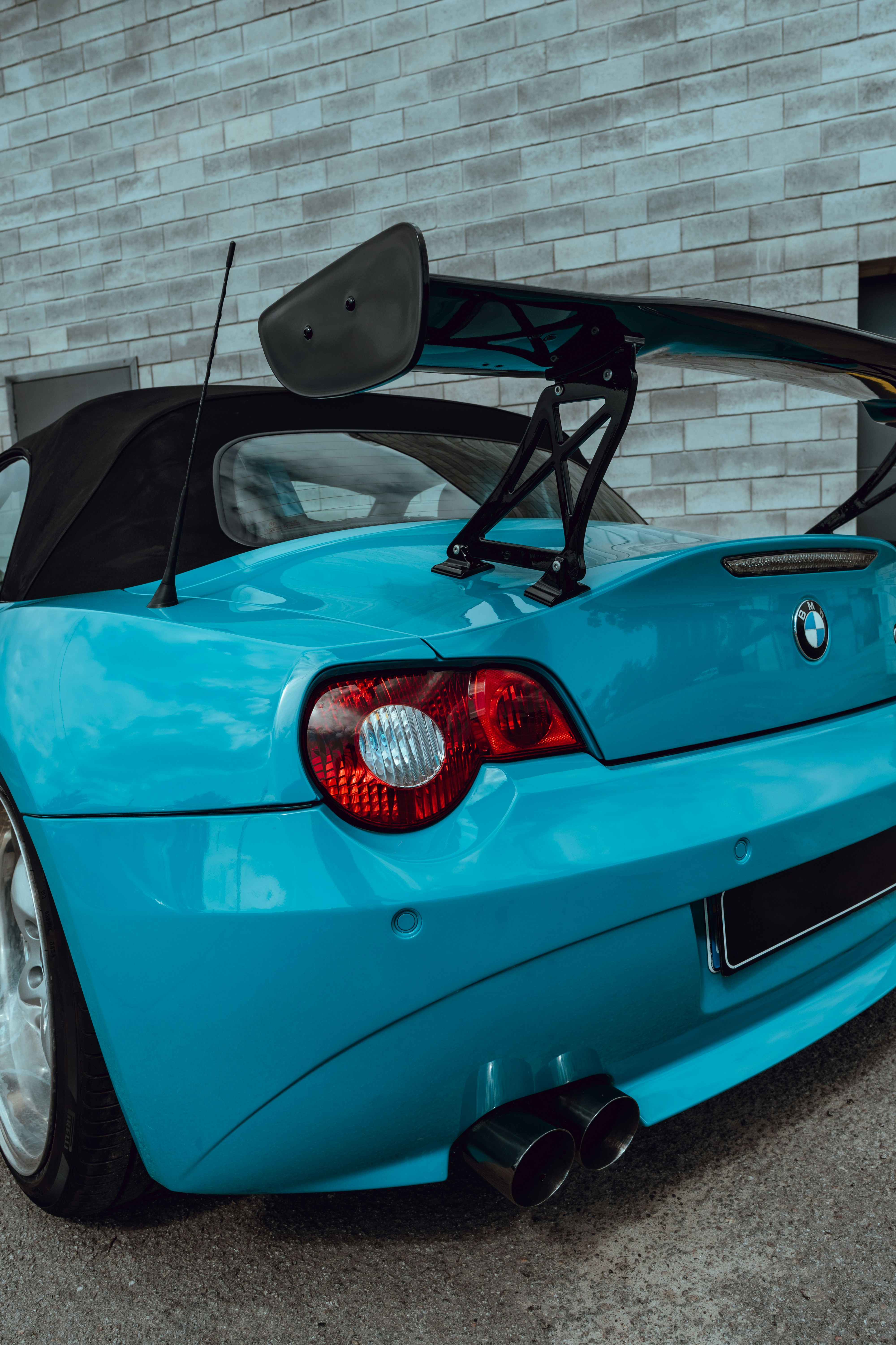 A blue BMW z4 convertible with a wing.