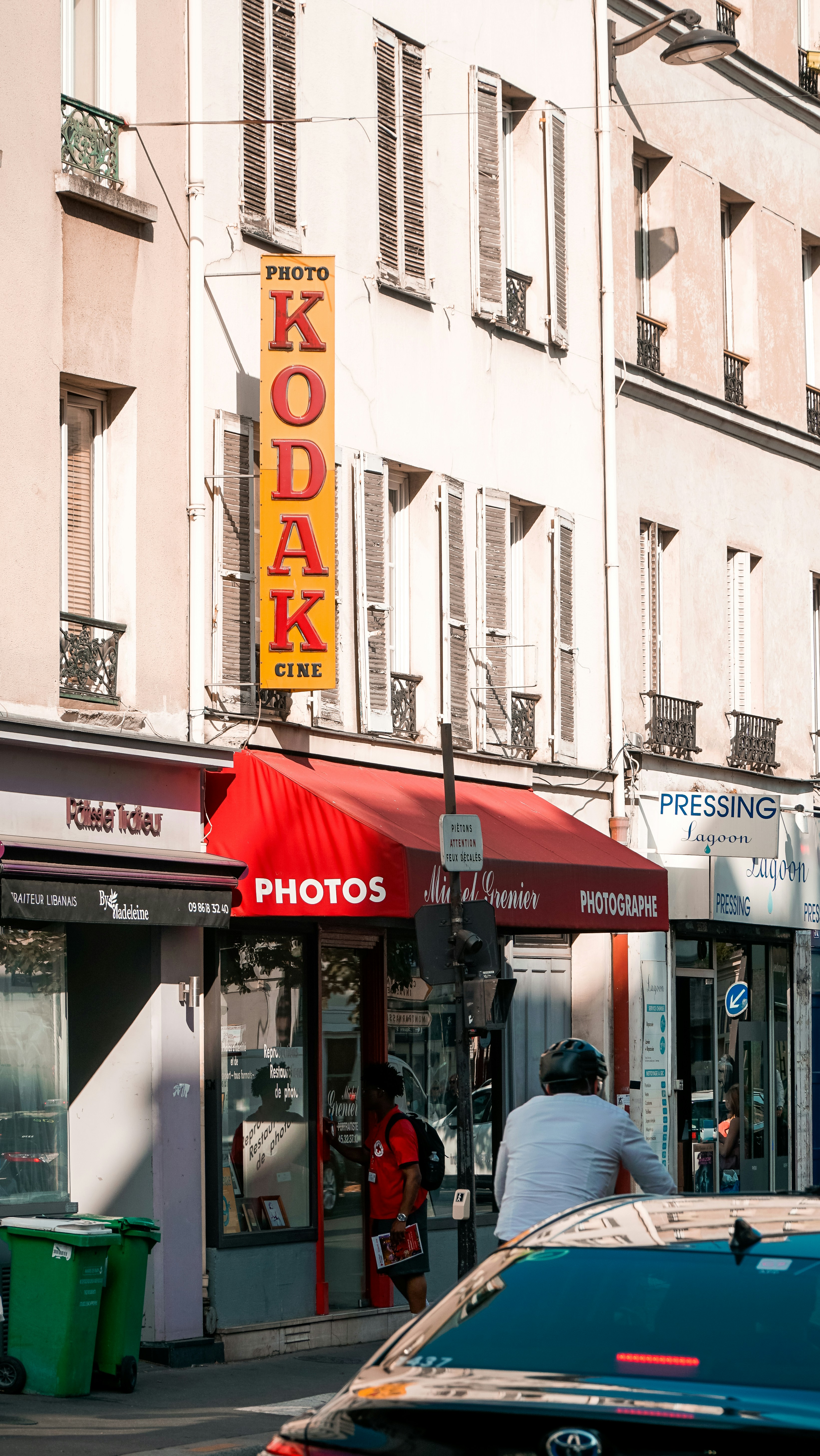 Vintage Kodak sign prominently displayed above a photography shop, capturing the essence of film nostalgia in a bustling urban setting.