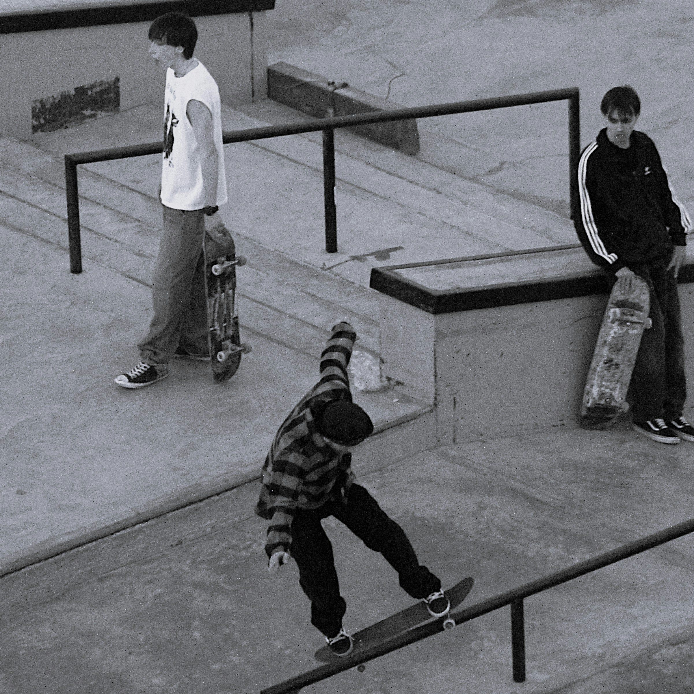 Skaters are at a skate park, performing tricks.