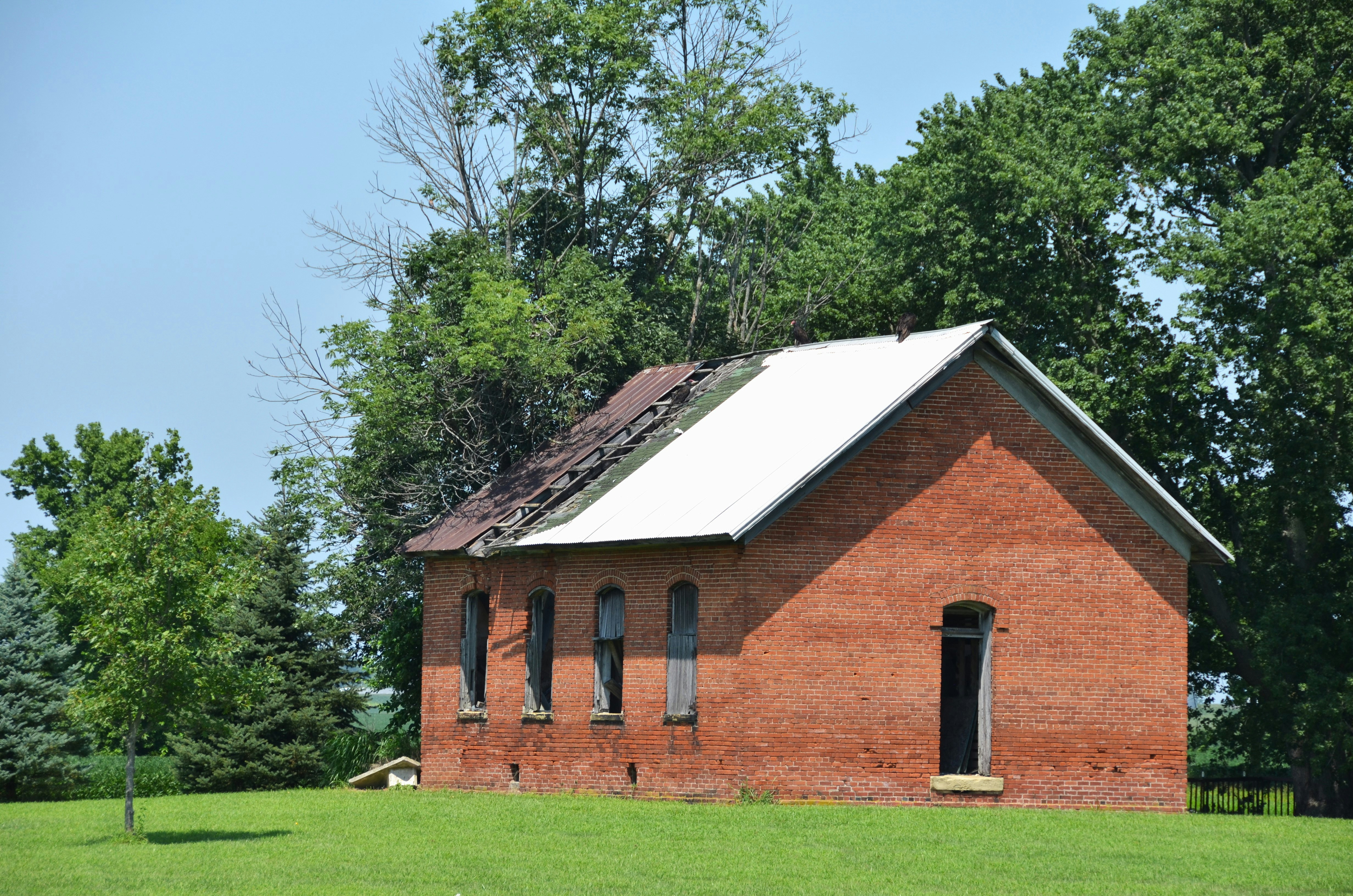 Old brick building with a damaged roof.
