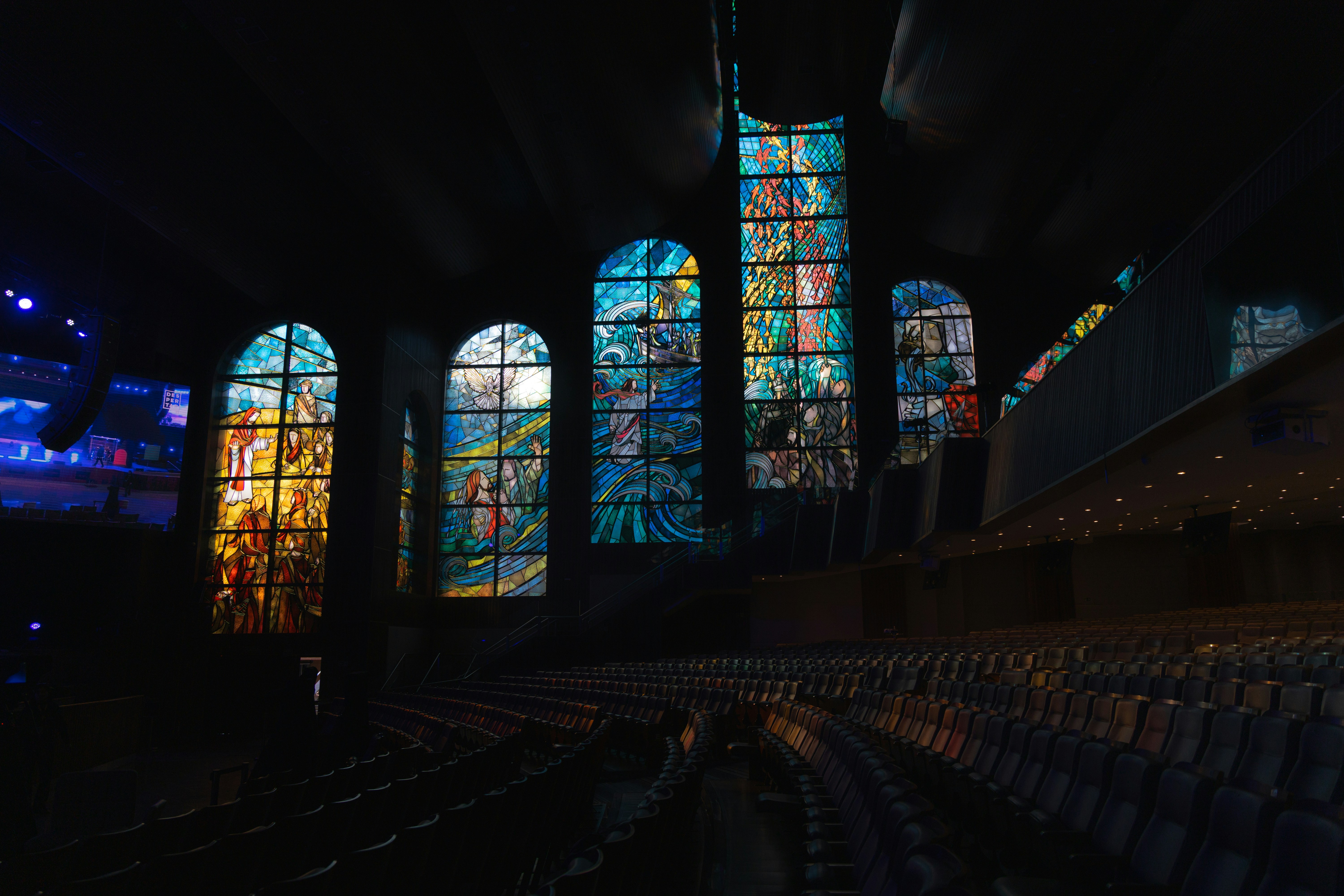 Colorful stained glass windows light up a dark auditorium. photo – Free ...
