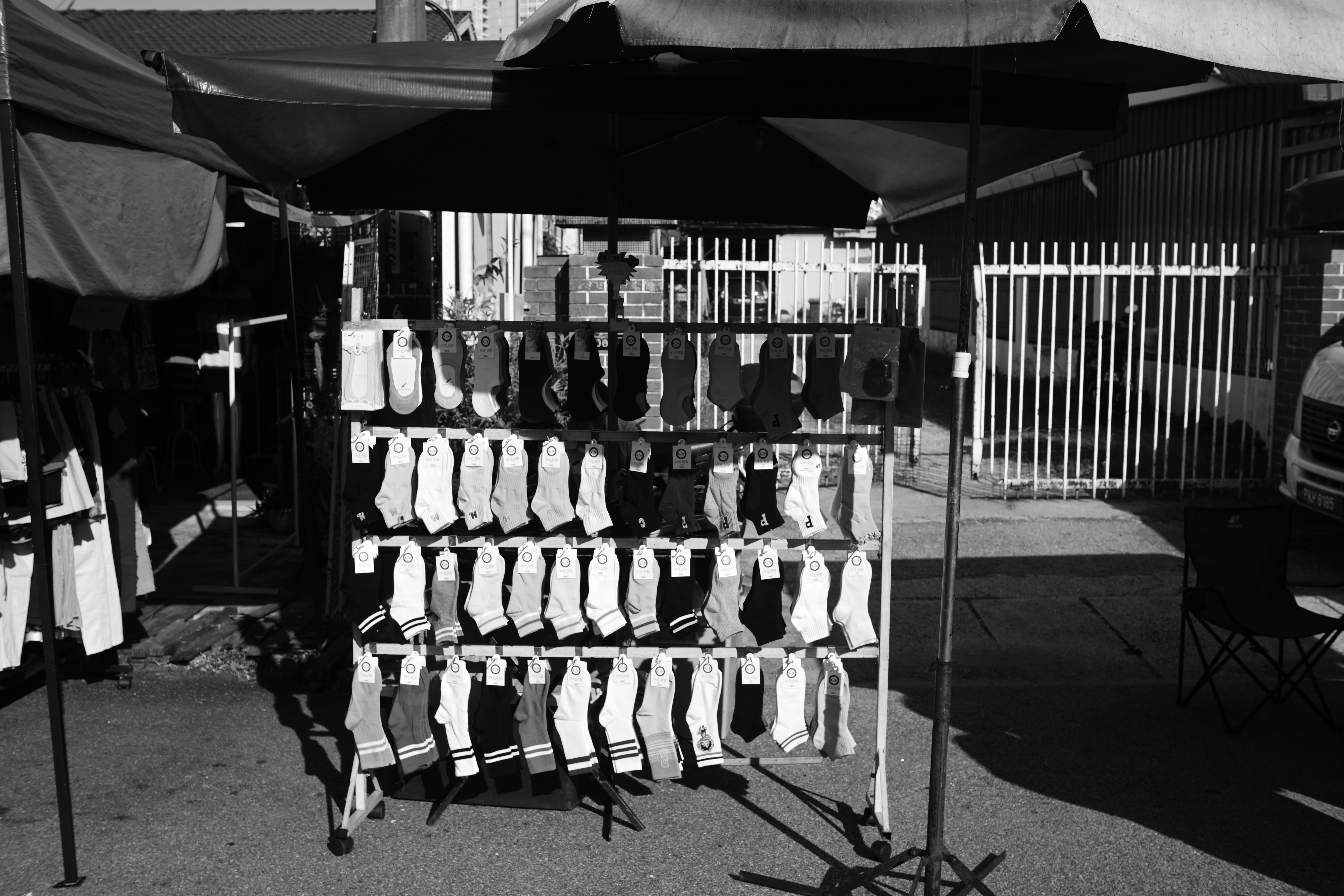 Grey Rows of Socks Under a Market Canopy