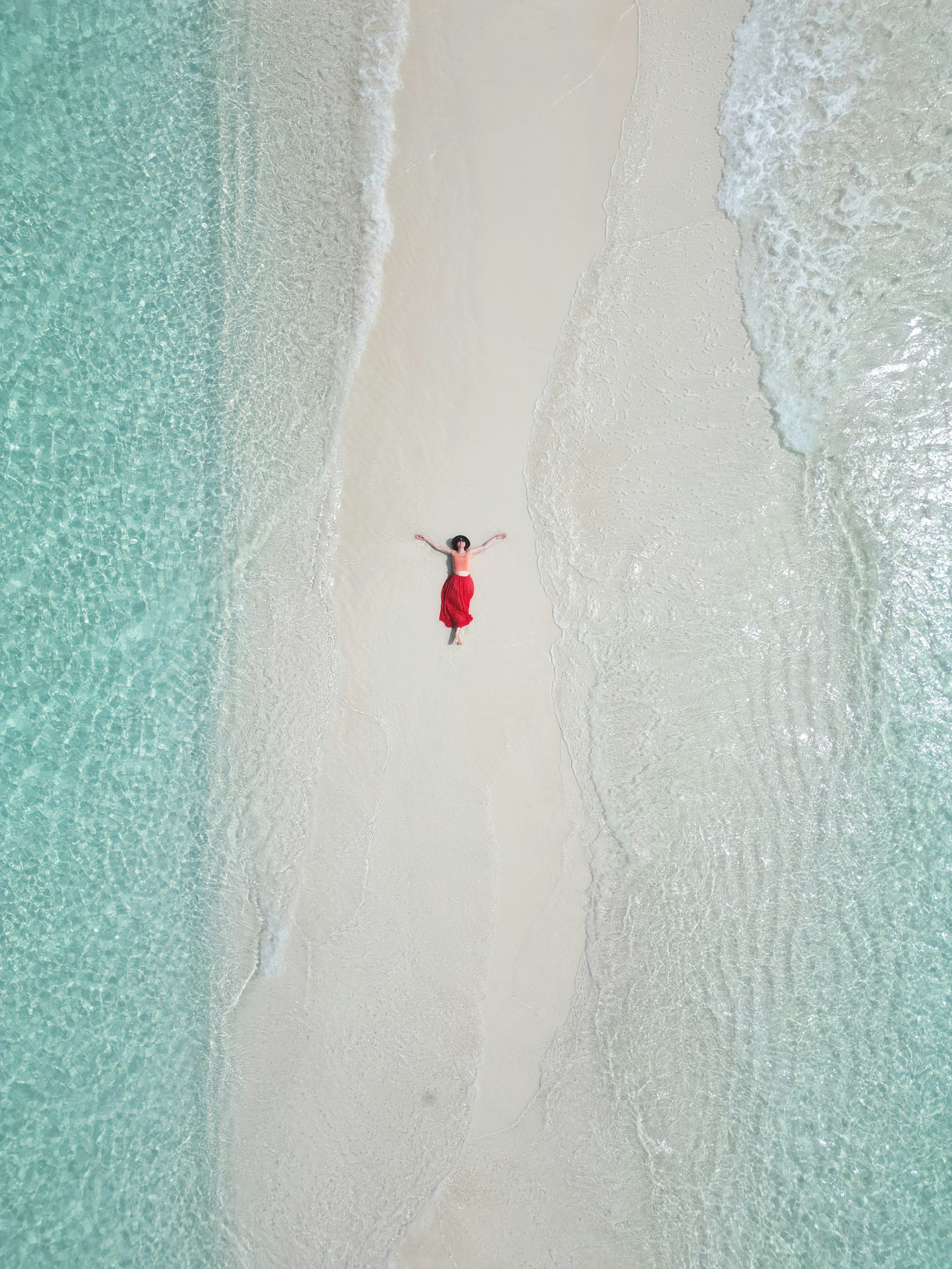 Person in red lies on a beach between the waves. photo – Free Beach ...