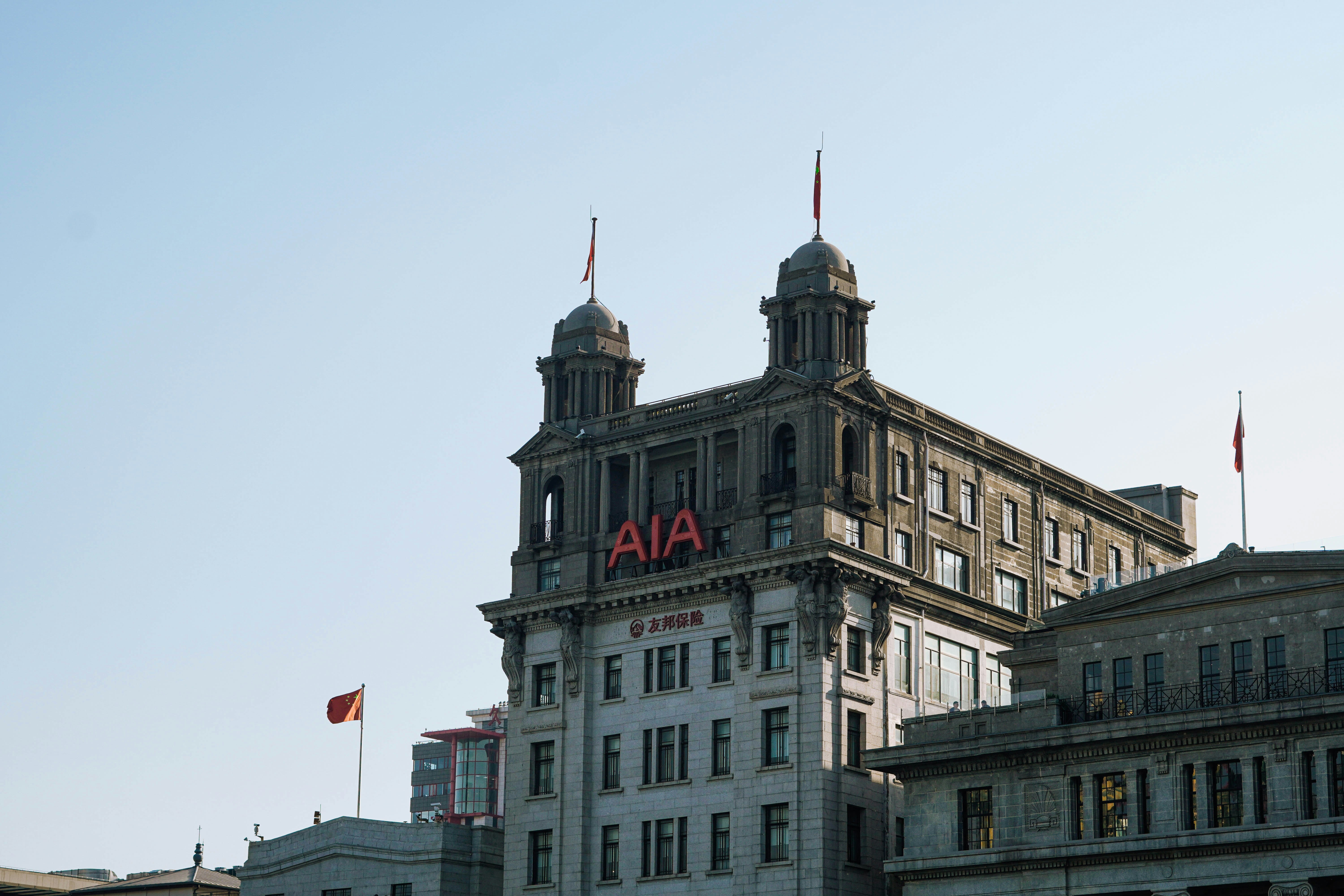 An aia building stands tall against a clear sky. photo – Free City ...