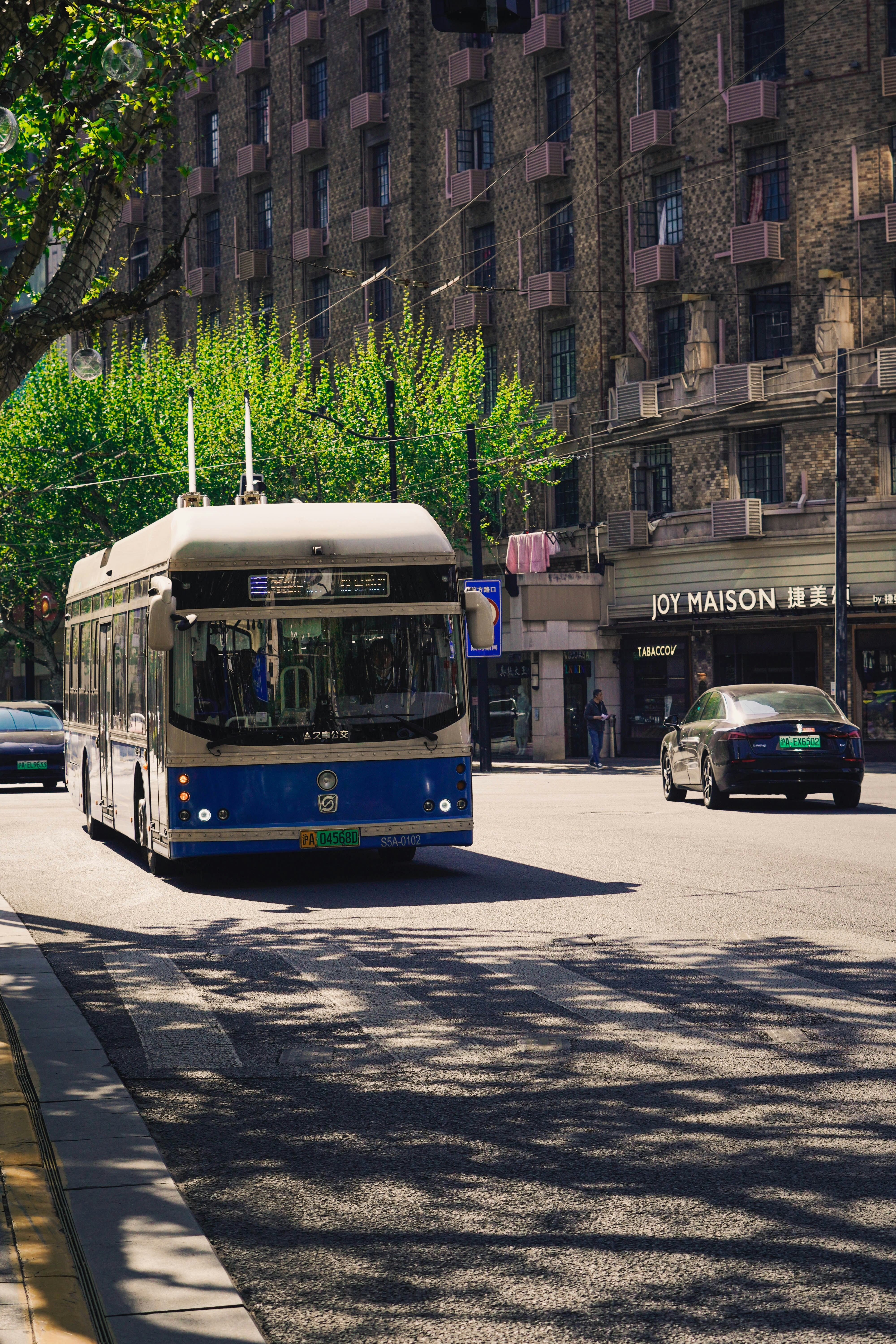 A trolley bus moves down a city street.