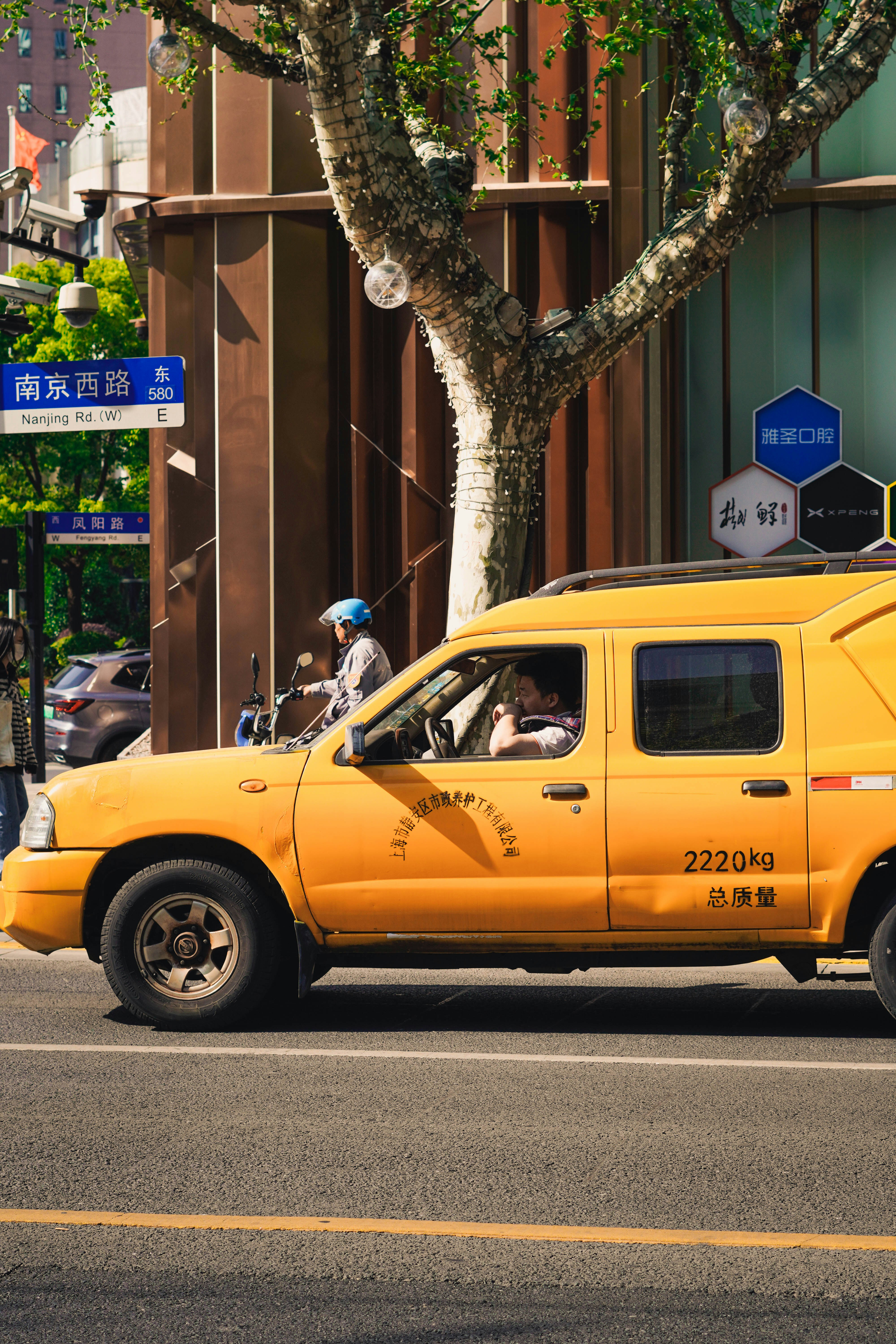 A yellow taxi car drives down the street.