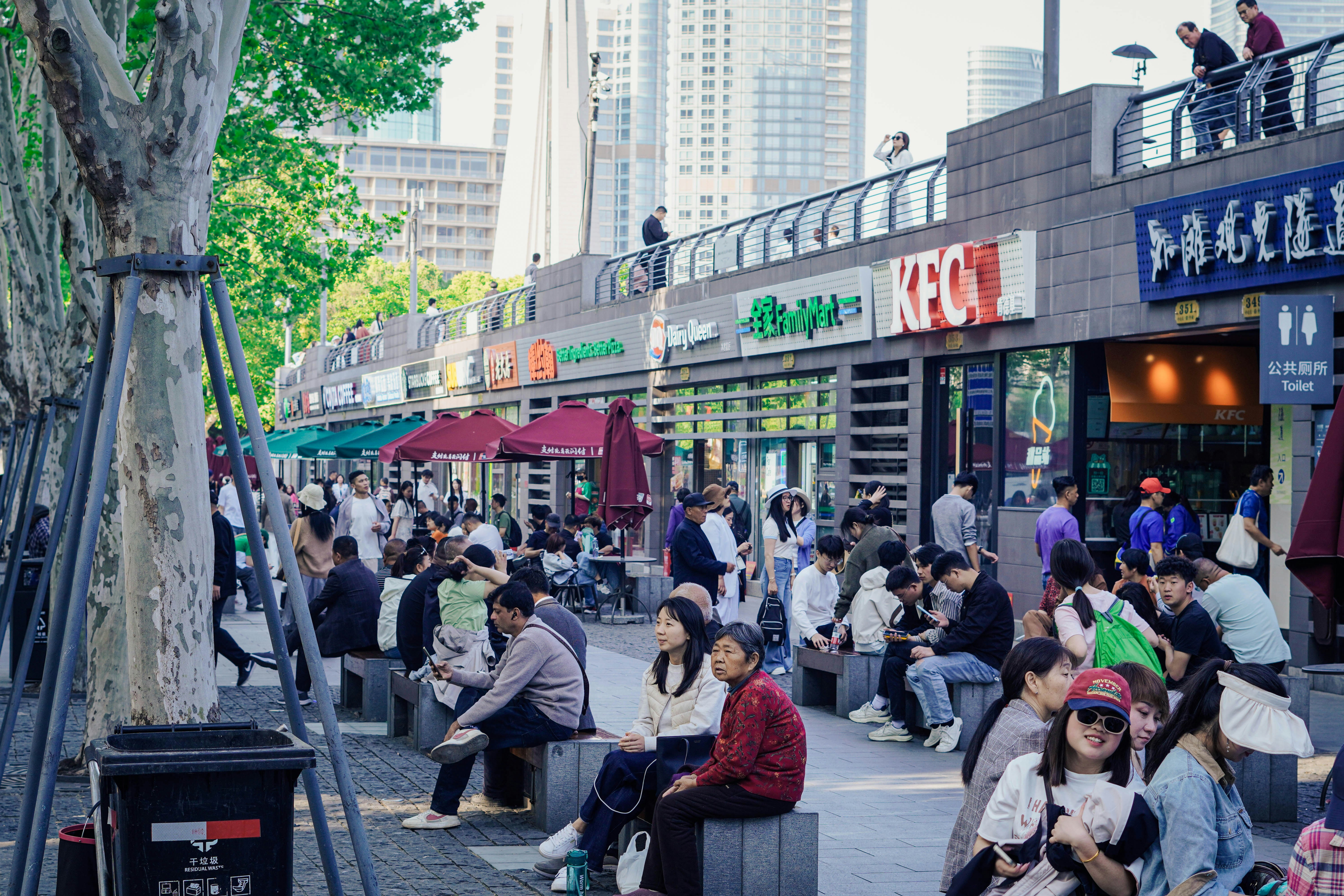 People are gathered in front of storefronts.