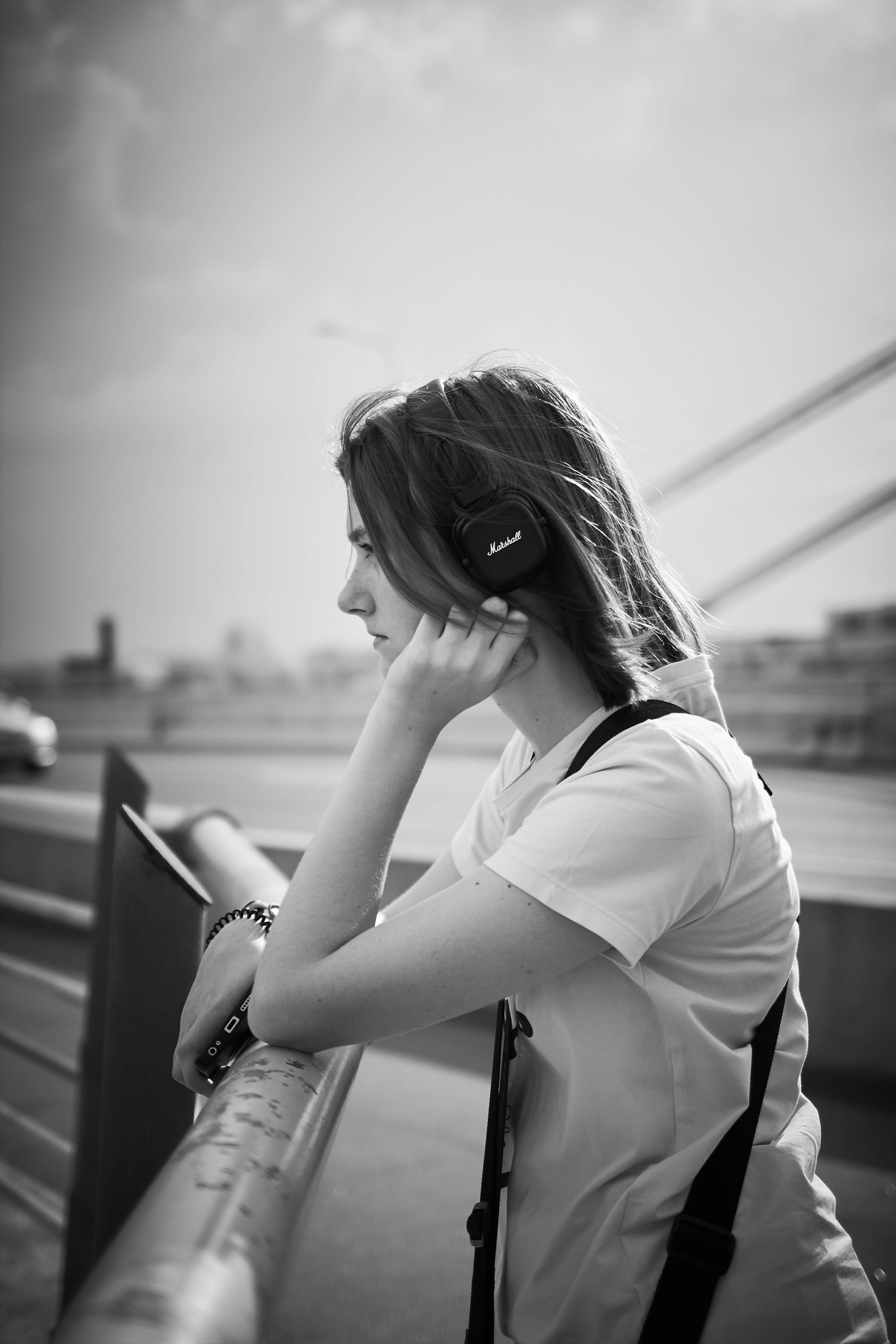 Young woman listens to music, gazing at the view.