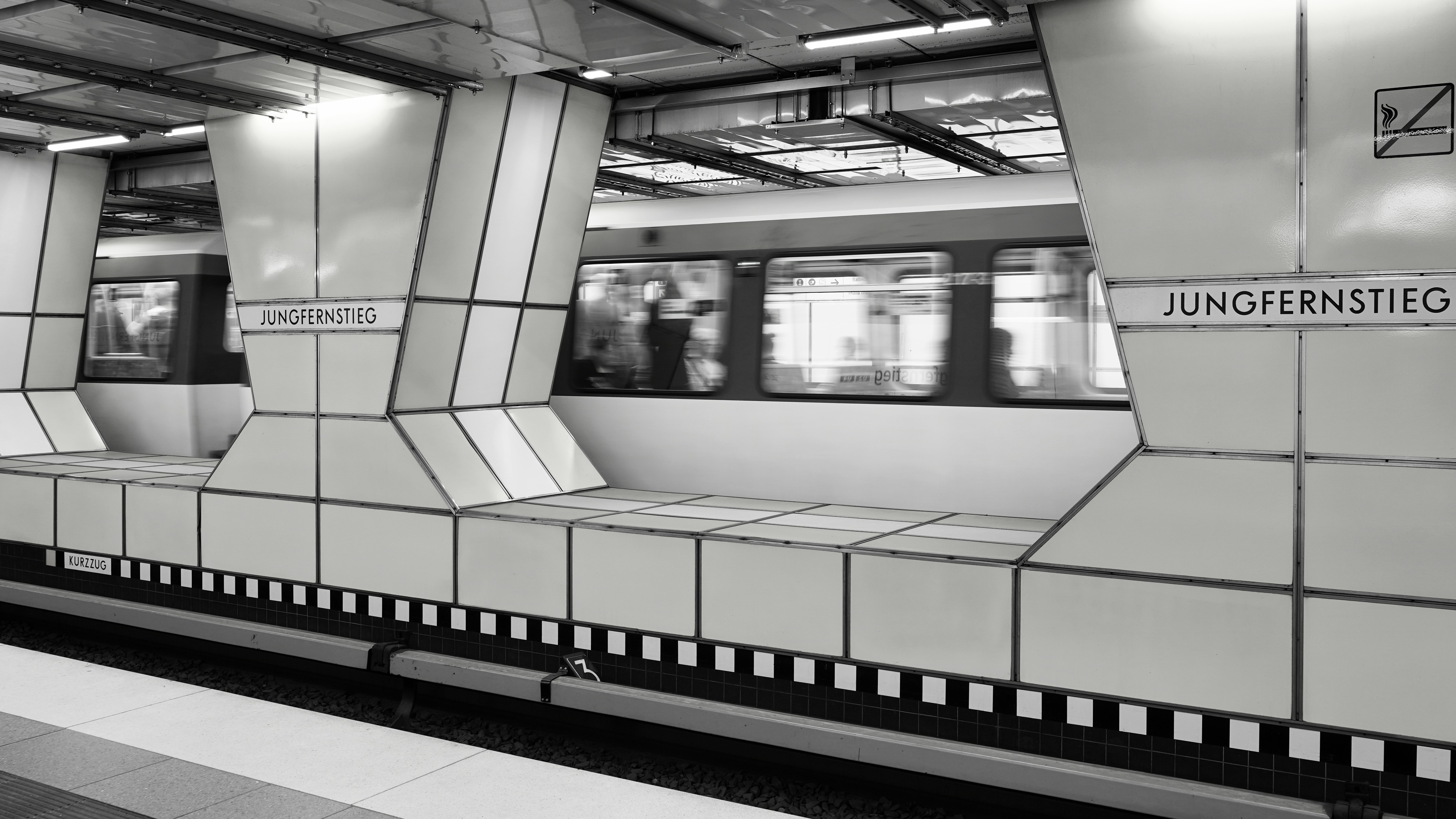 A subway train whizzes through a modern station.