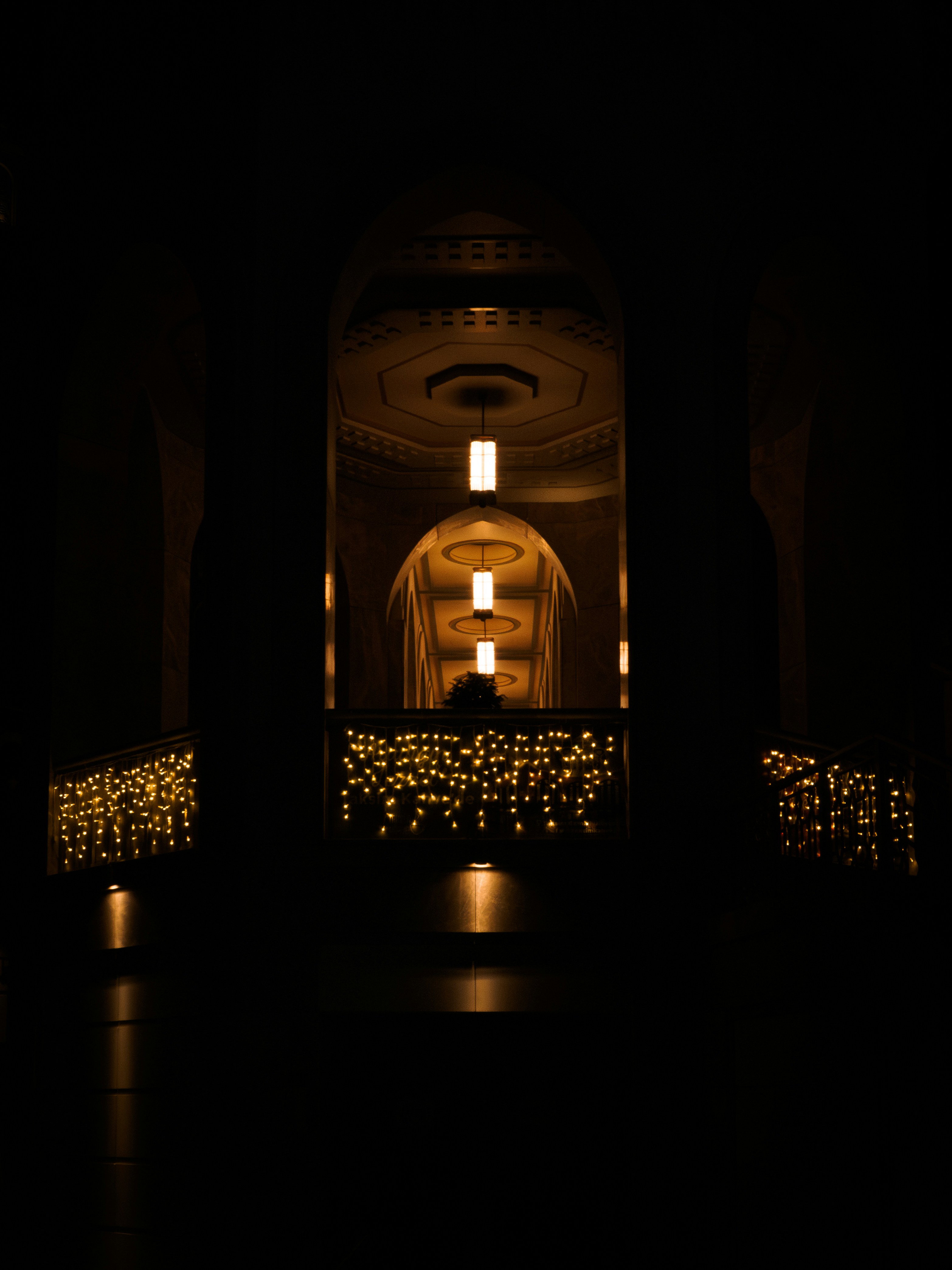 Golden lights illuminate an ornate, dark passageway.