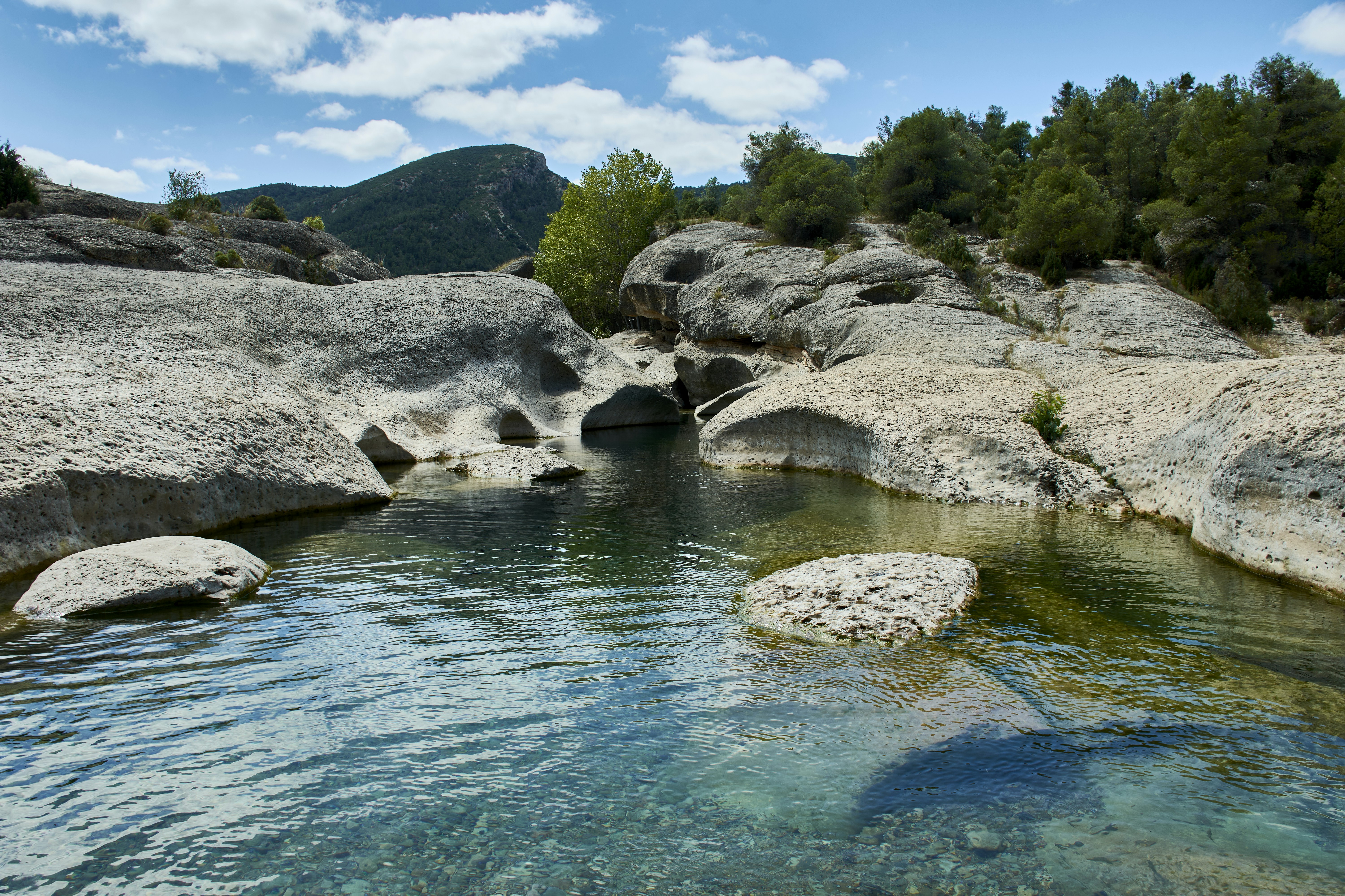 Clear water flows through rock formations.