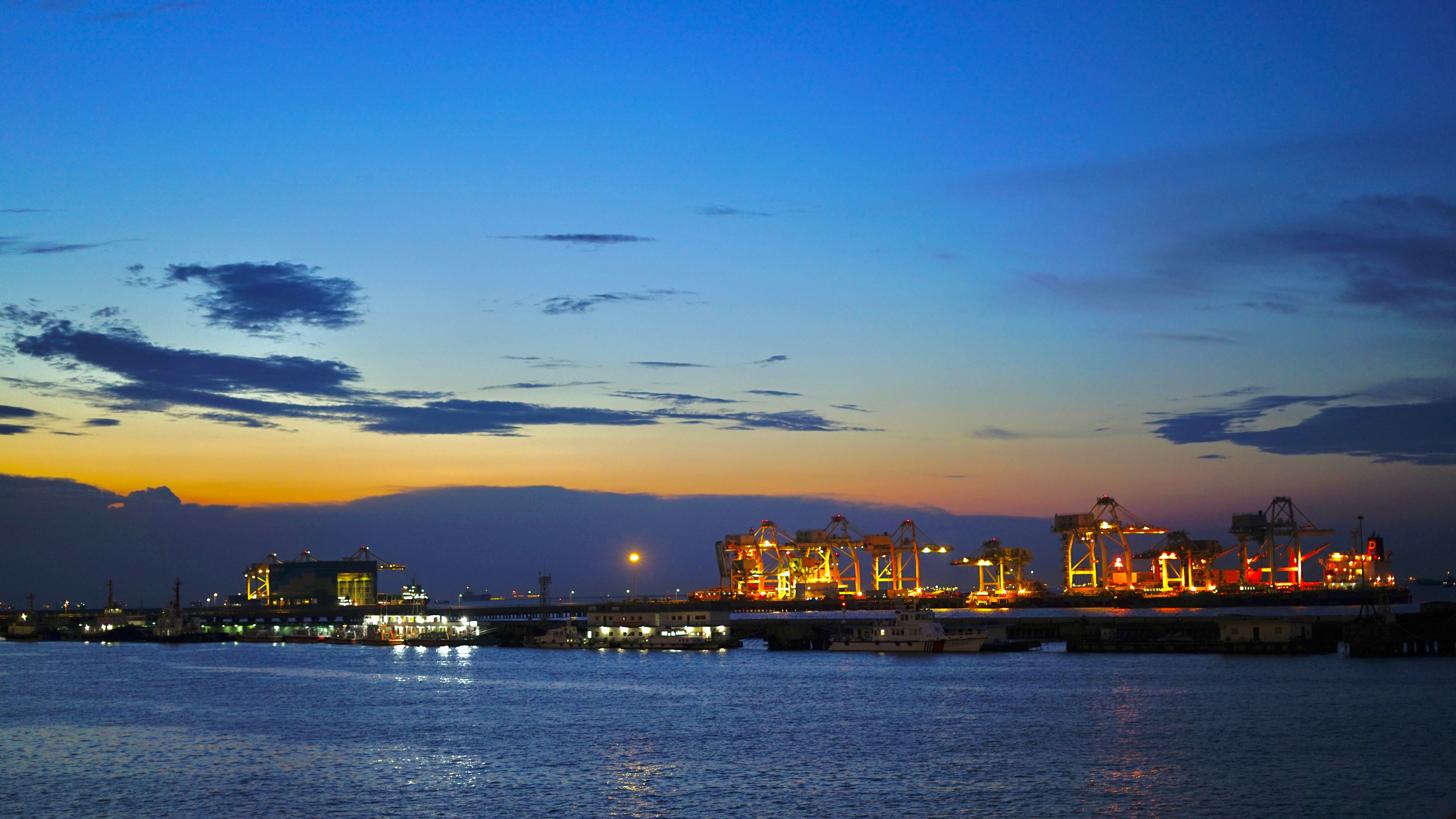 Dusk descends over a lit-up cityscape by water.