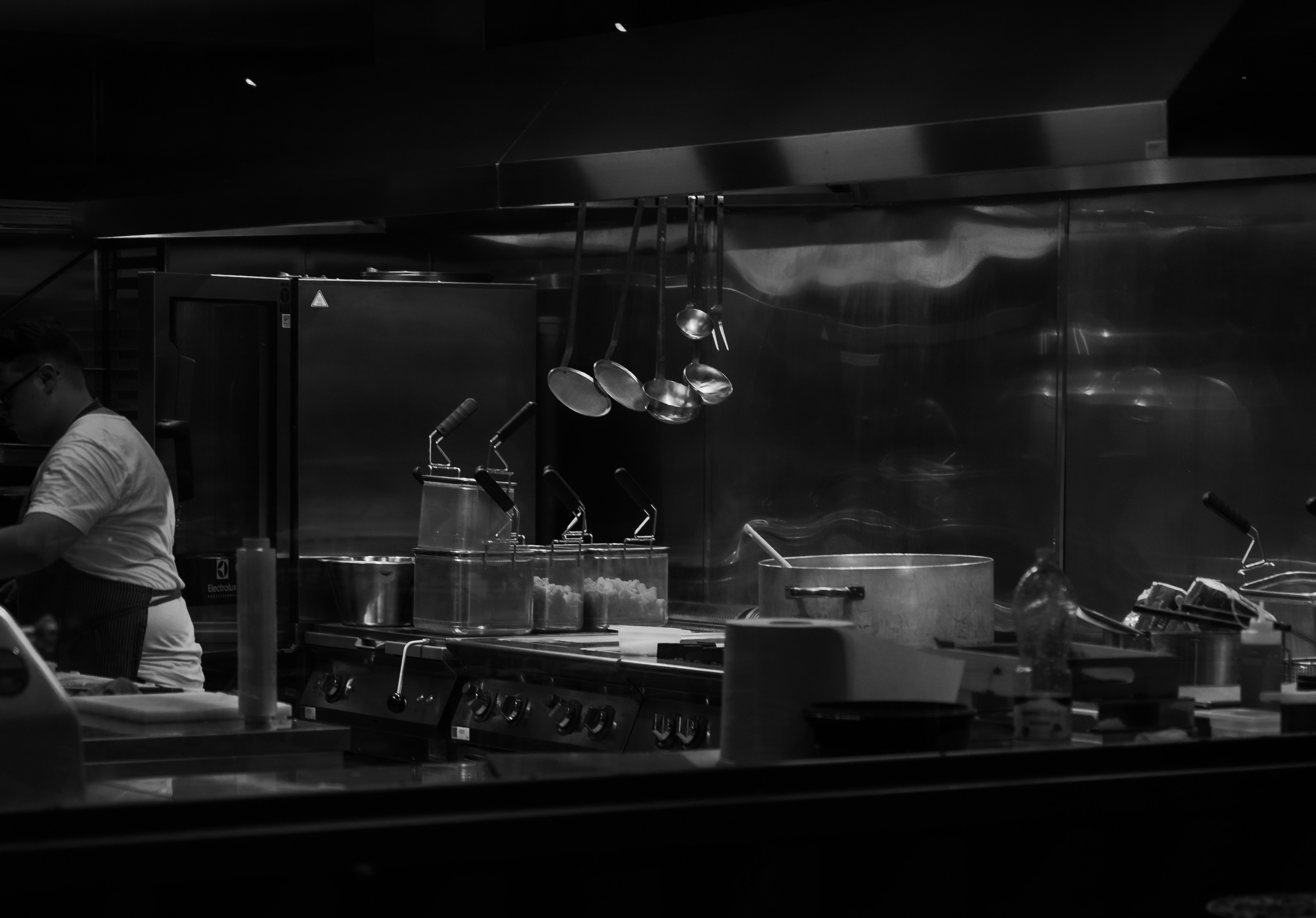 Chef at work in a bustling kitchen, surrounded by gleaming pots and pans, reflecting the artistry of culinary preparation.