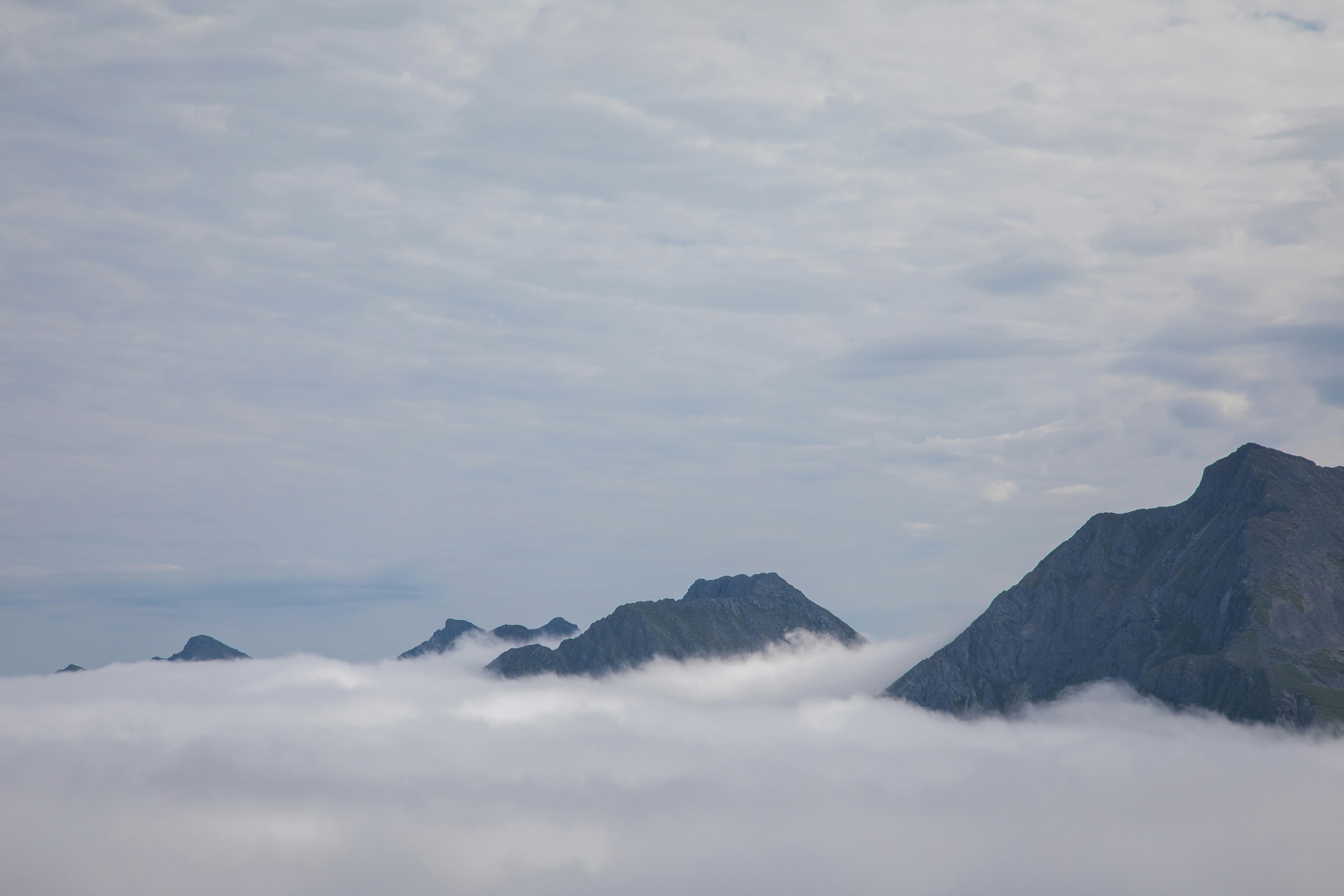 Mountains peak through the clouds.