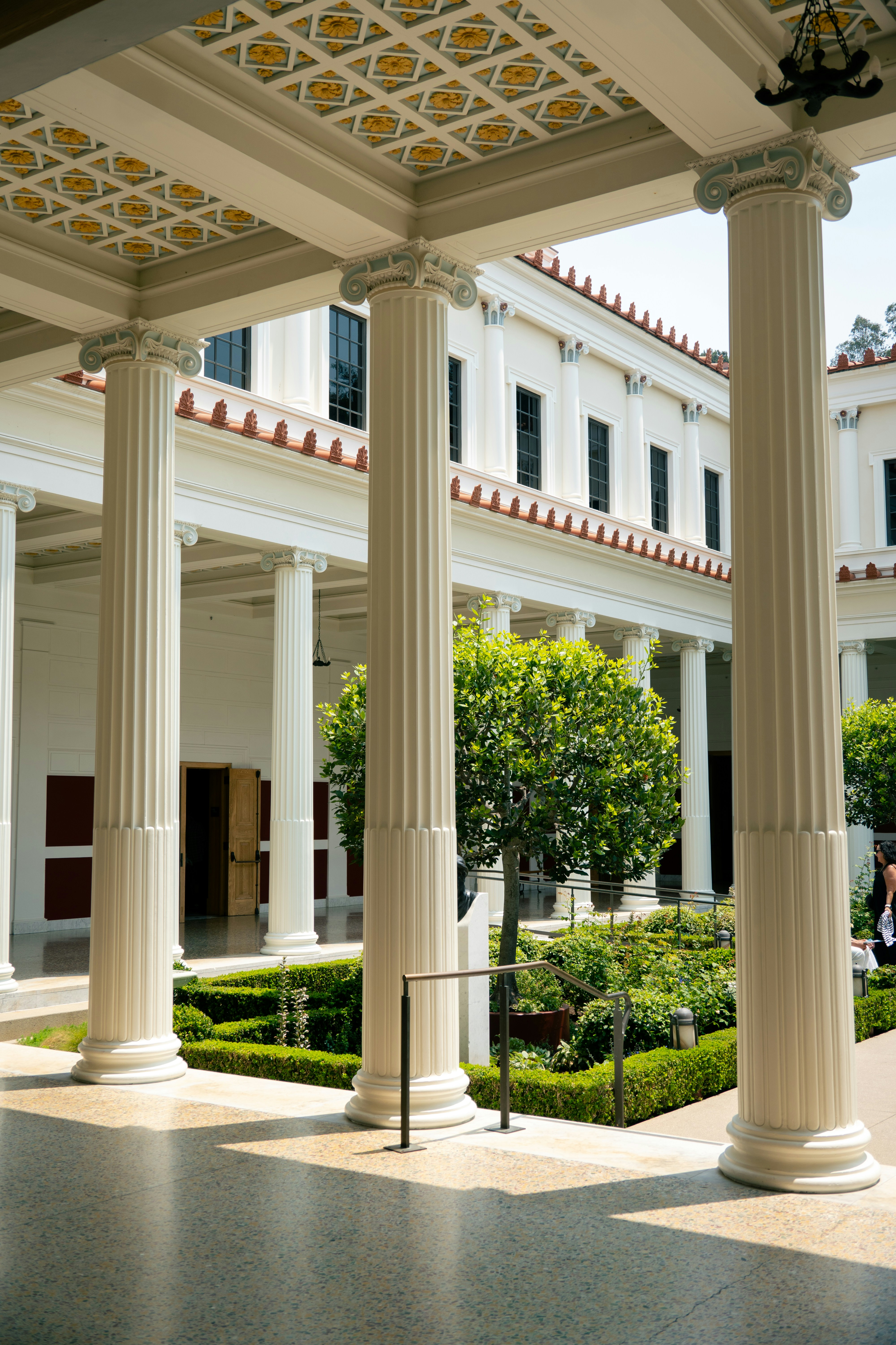 Columns frame a beautiful courtyard with lush greenery.