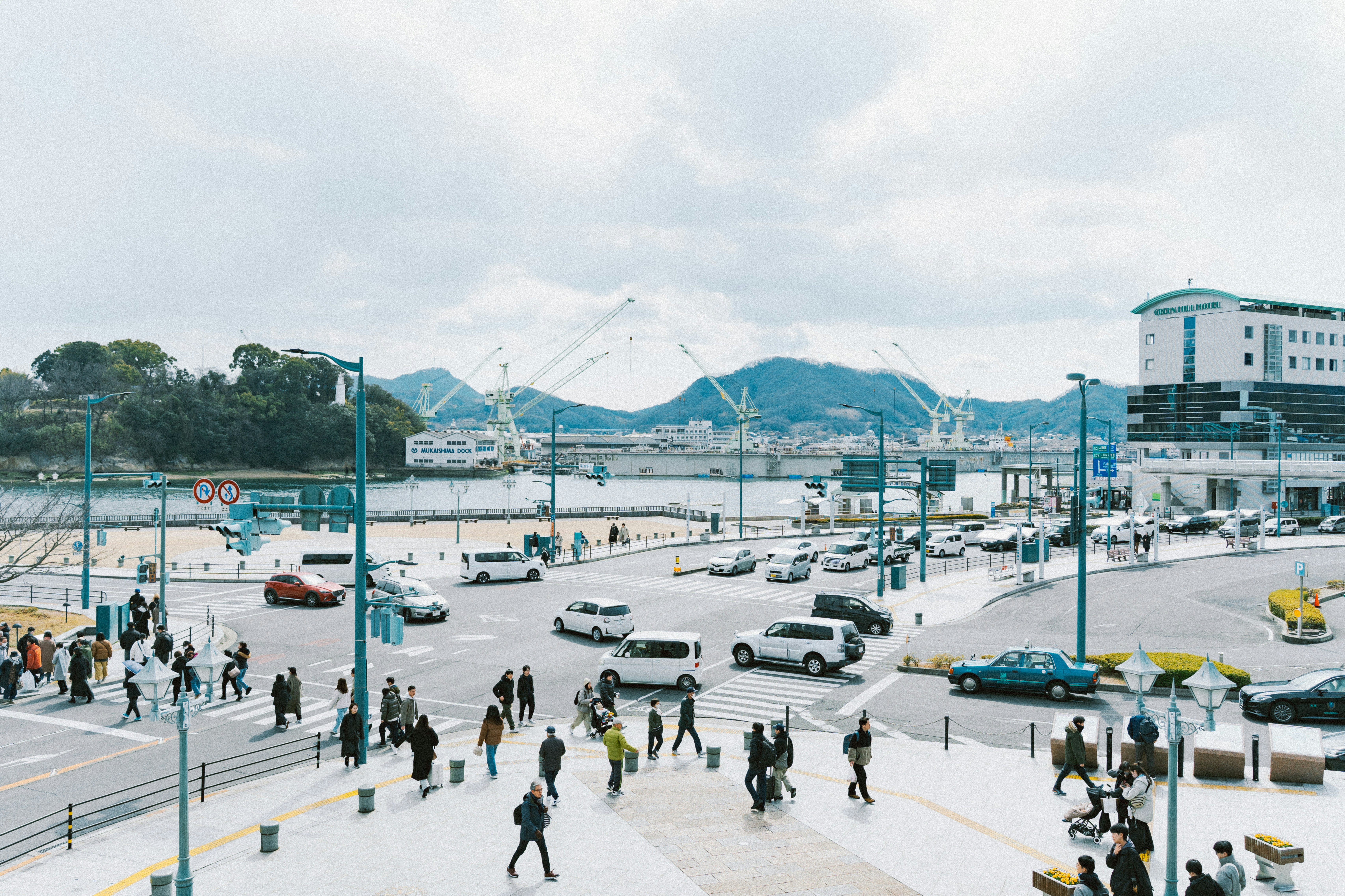 People and cars busy in an urban intersection.