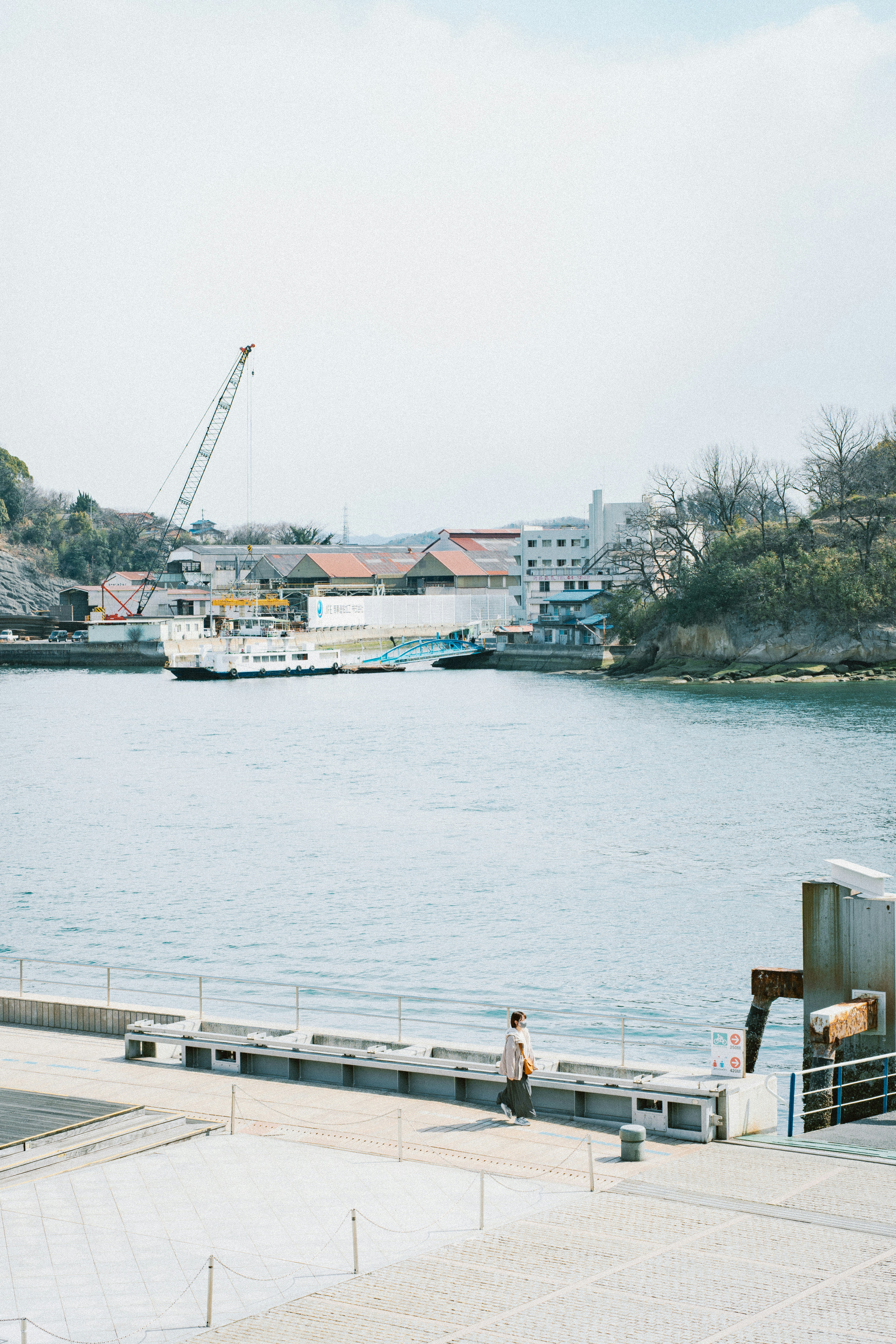 Harbor Pier Solitude: A Lone Figure Traces the Waterfront