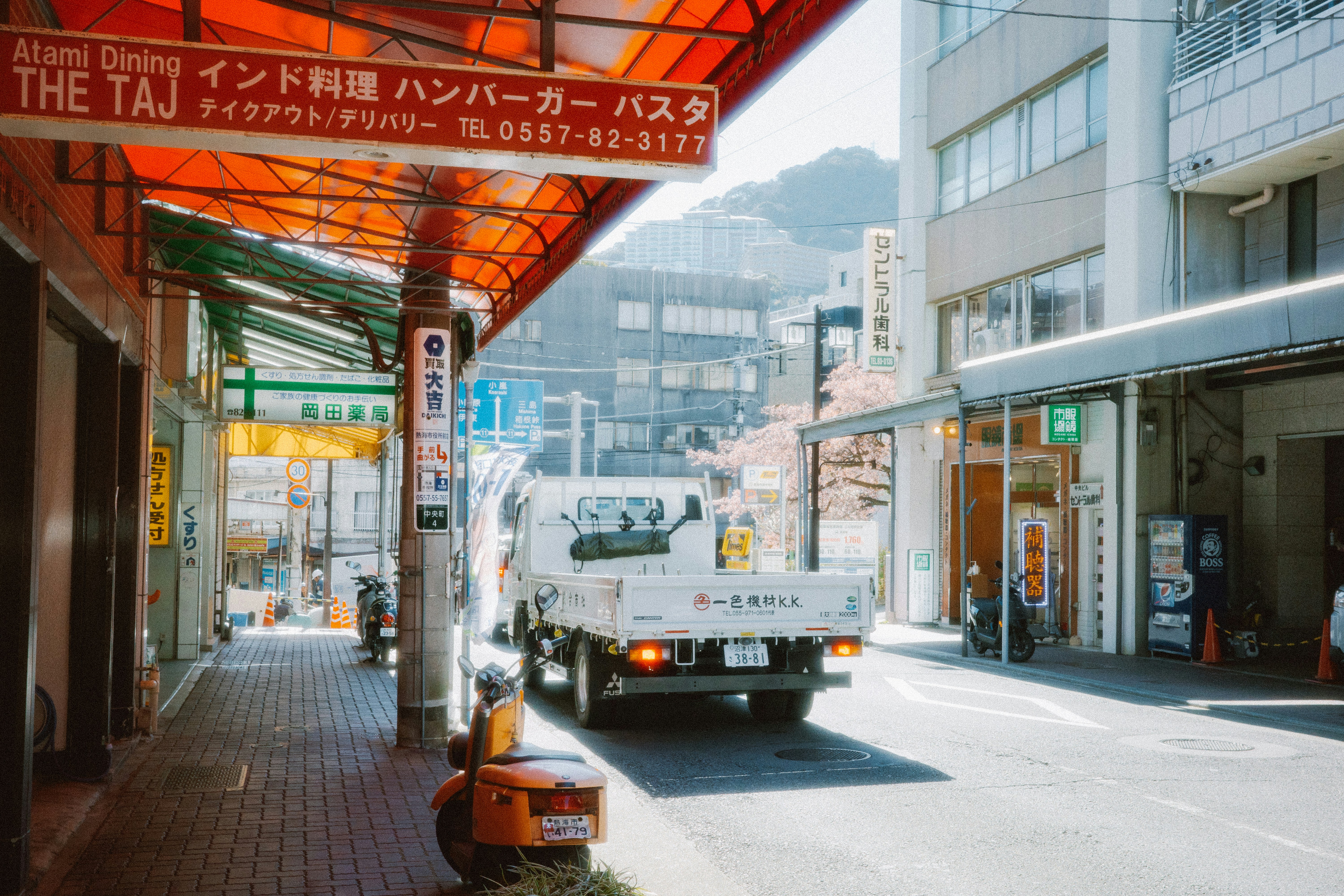 Under the Orange Canopy: A Quiet Street Scene with a Waiting Truck