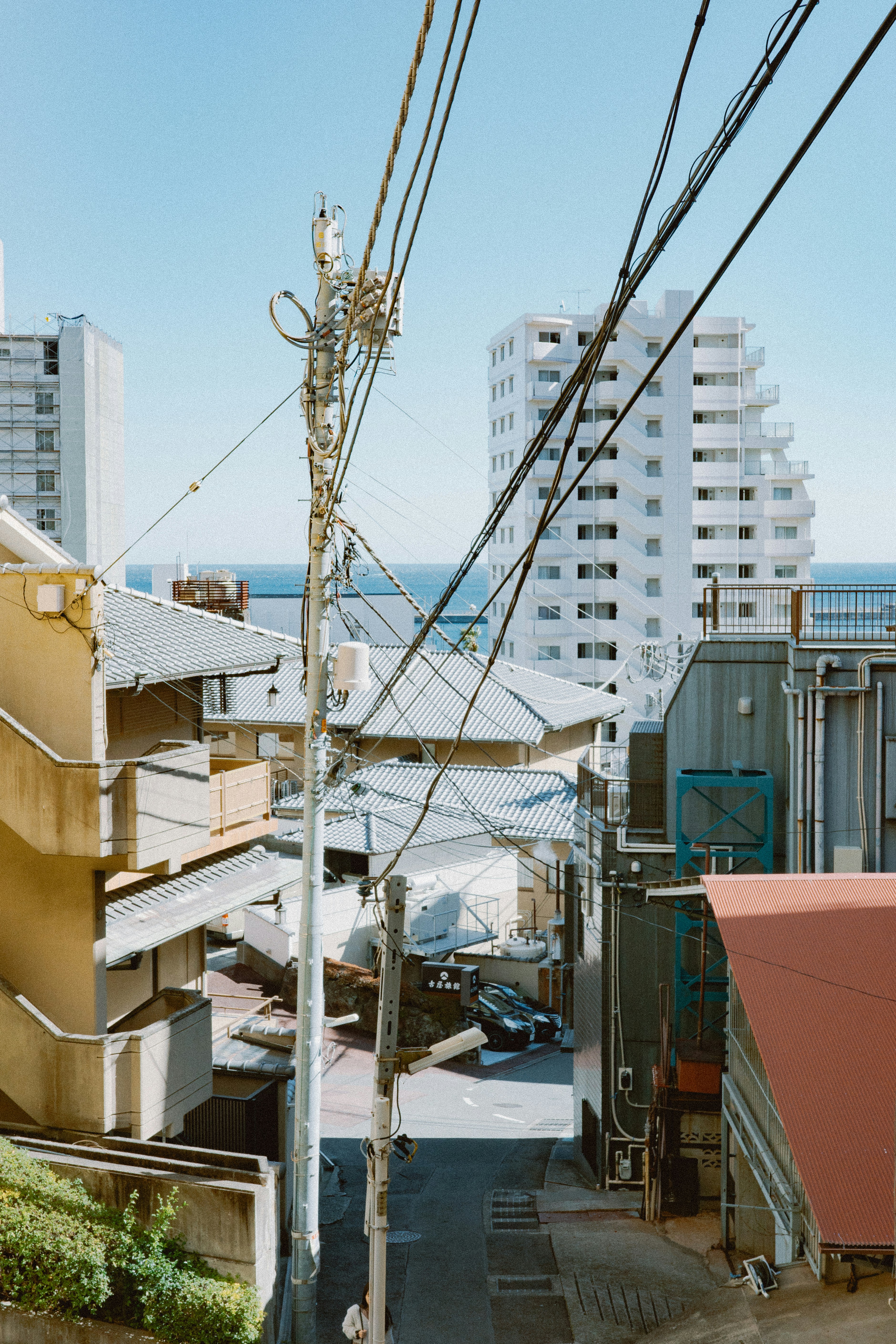 Wired Window to the Sea: A Sunlit Coastal Street