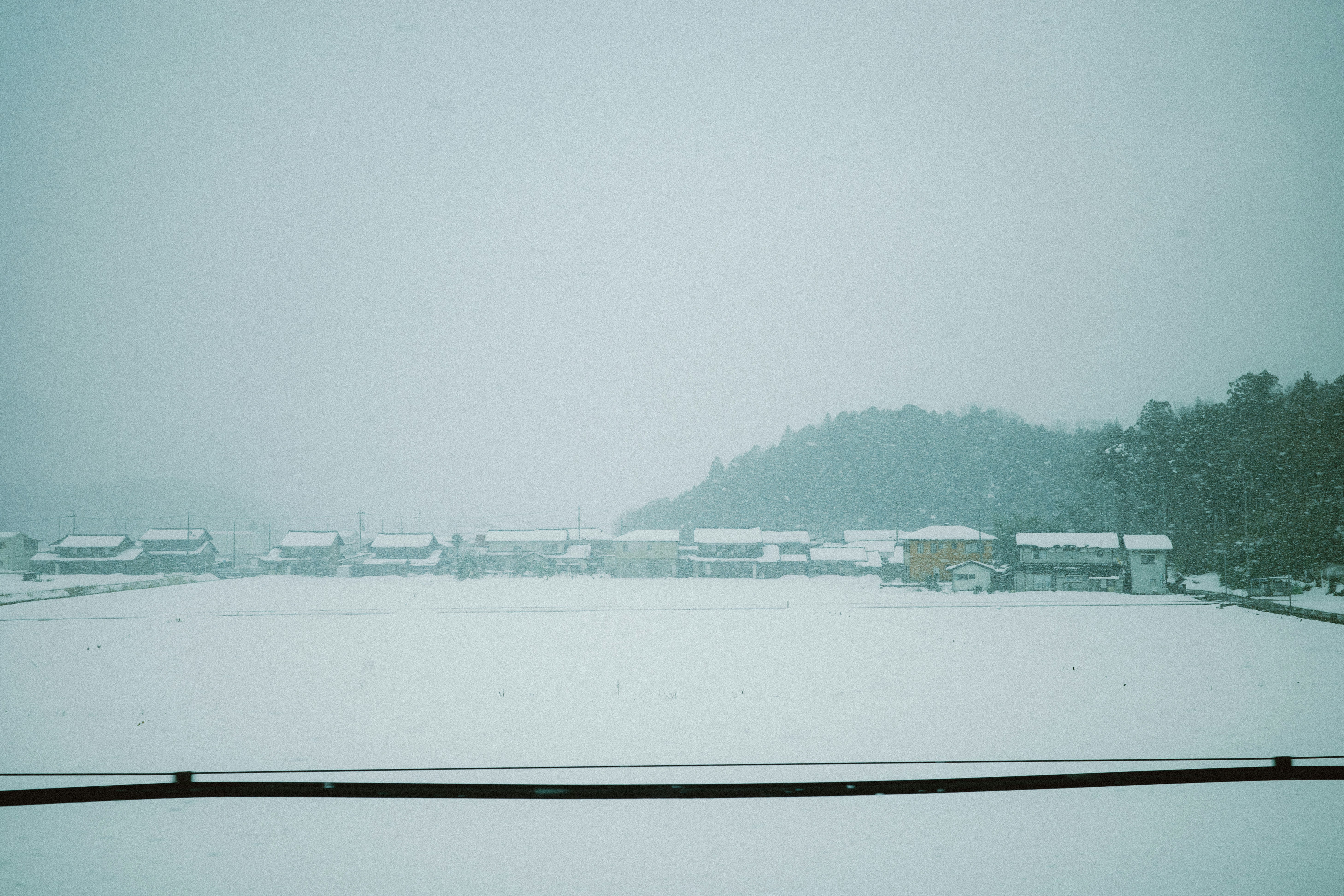 Whispers of Winter: A Snow-Cloaked Village
